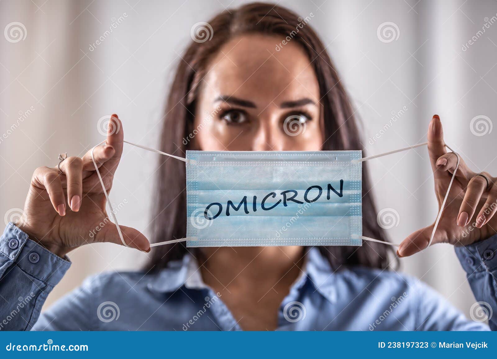 A Young Woman Puts on a Protective Mask with the Inscription Omicron ...