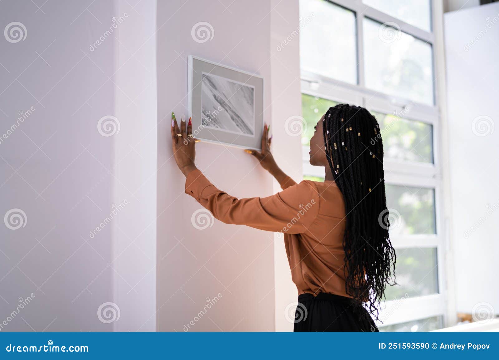Woman Putting Photo Frame on Wall Stock Photo - Image of house, beach ...