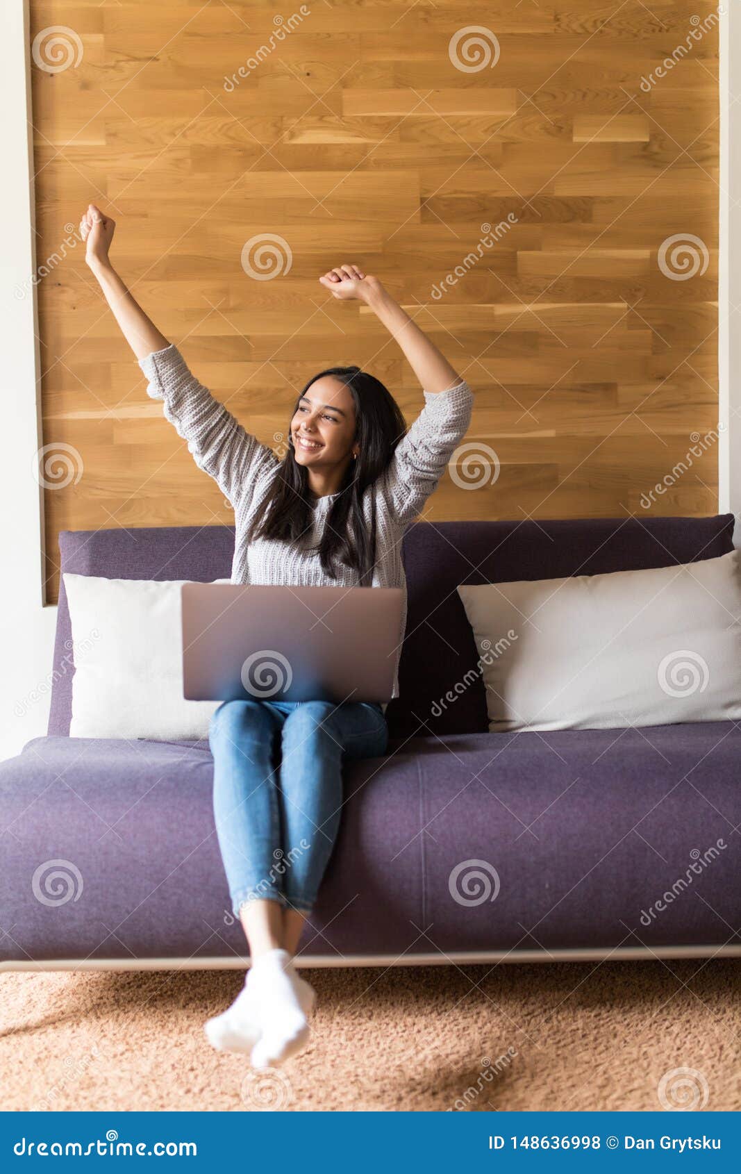 Young Woman Raising Her Hands Up on the Couch with Laptop at Home Stock ... Young Woman Raising Her Hands Up on the Couch with Laptop at Home Stock ...