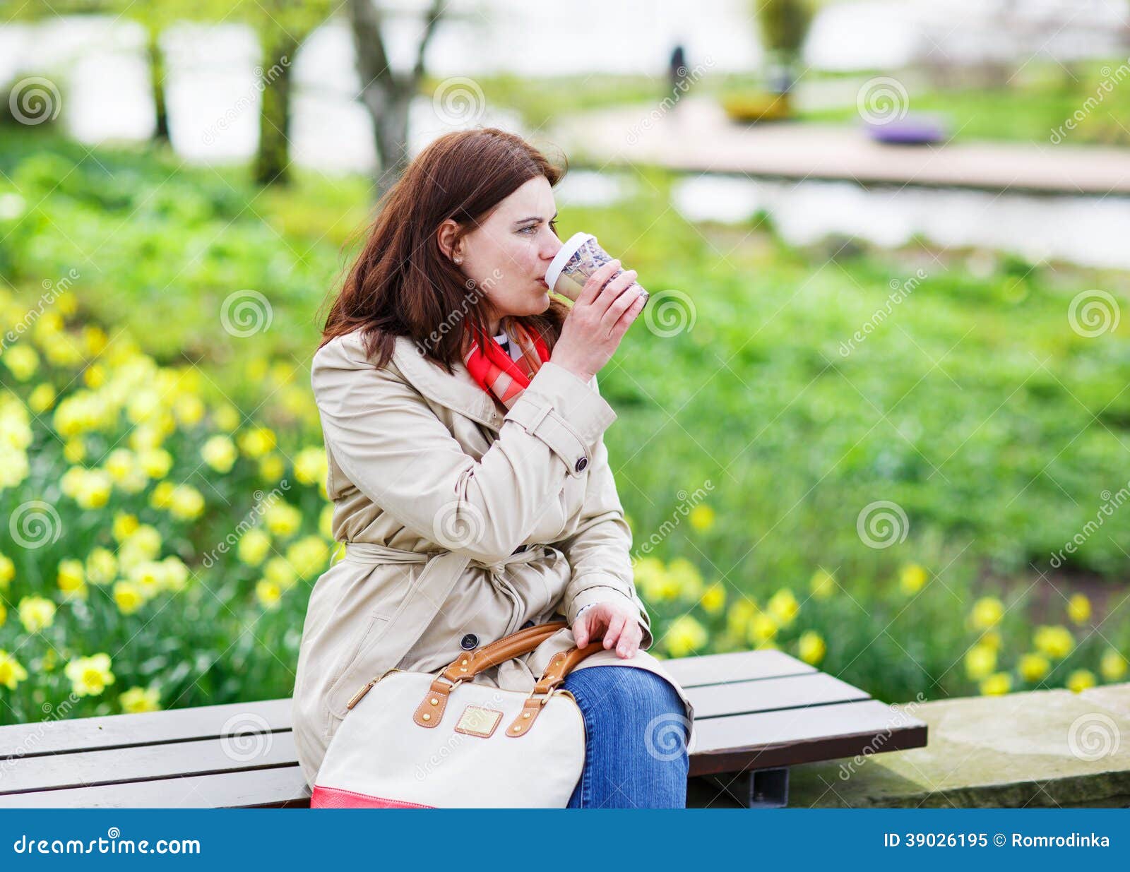 Young Woman Reading Book and Drinking Coffee in Spring Park. Stock ...