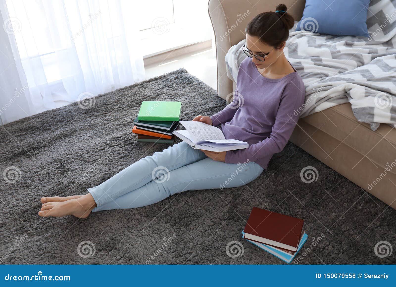 Young Woman Reading Book on Floor at Home Stock Photo - Image of ...