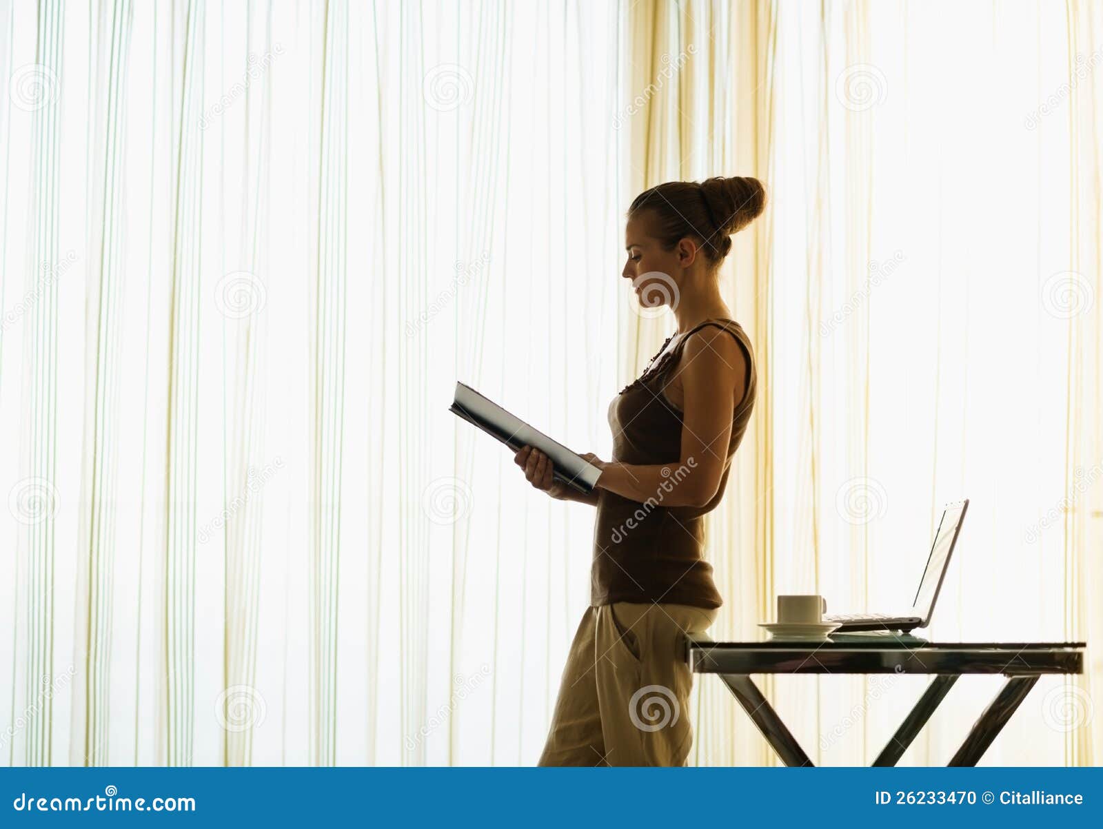 Young Woman Reading Book Leaning Against Table Stock Photo - Image of ...