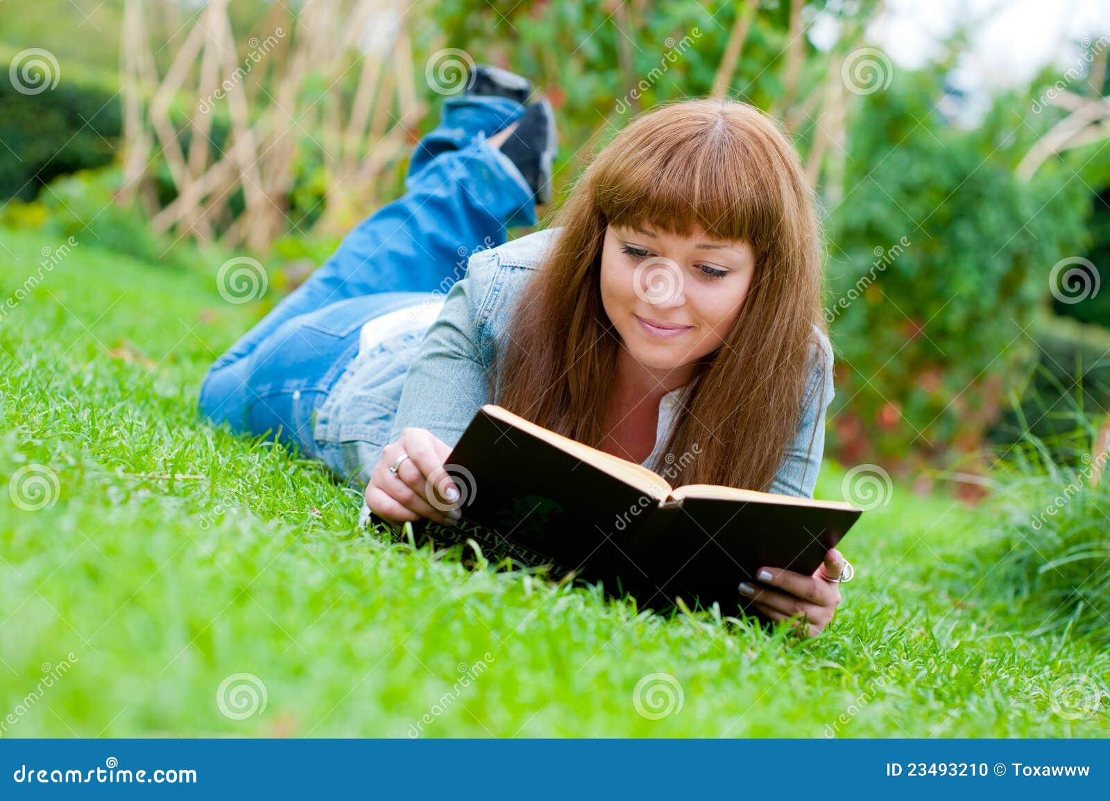 Young Woman Reading a Book Lying on the Grass Stock Photo - Image of ...