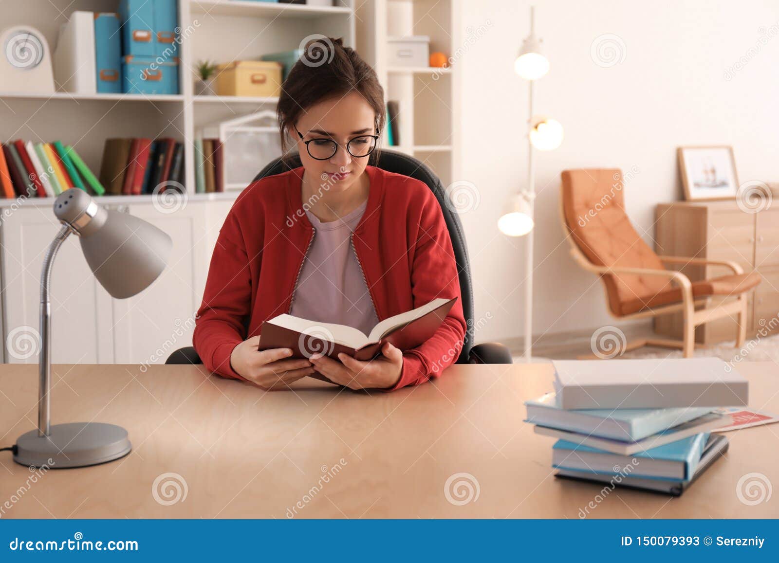 Young Woman Reading Book at Table Indoors Stock Image - Image of ...