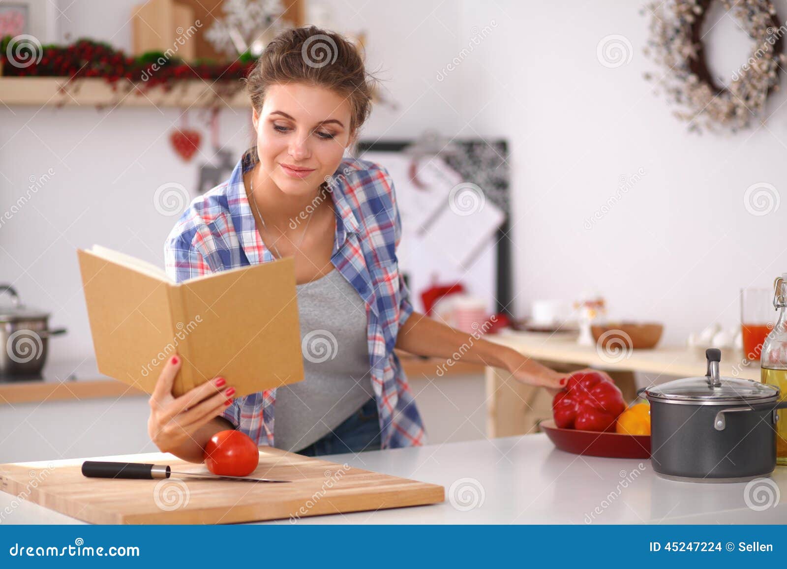 Young Woman Reading Cookbook in the Kitchen, Stock Photo - Image of ...