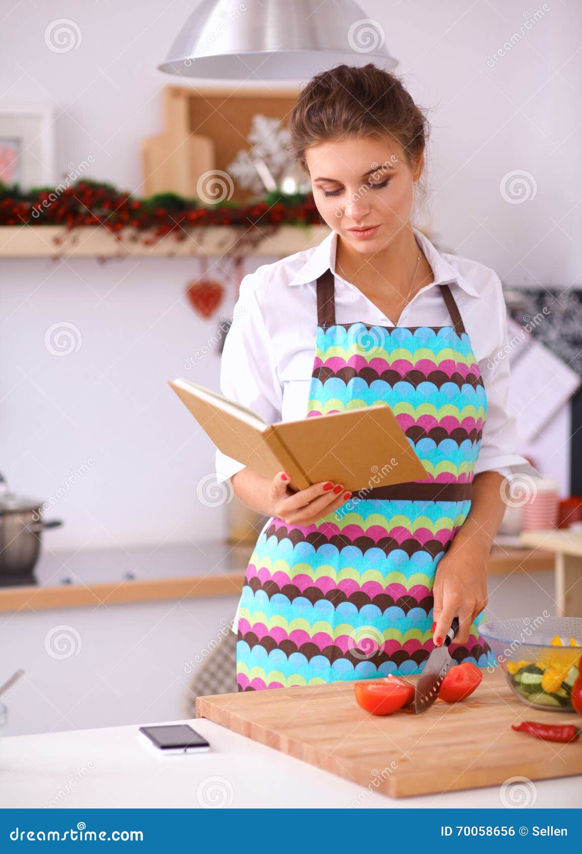 Young Woman Reading Cookbook in the Kitchen, Looking for Recipe Stock ...