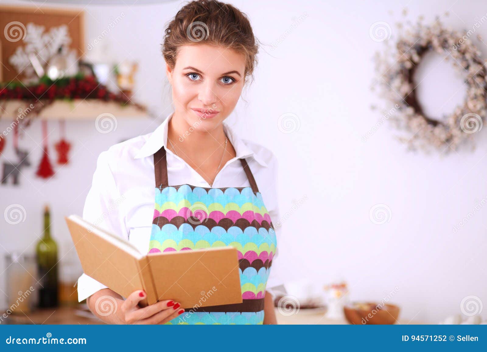 Young Woman Reading Cookbook in the Kitchen, Looking for Recipe Stock ...
