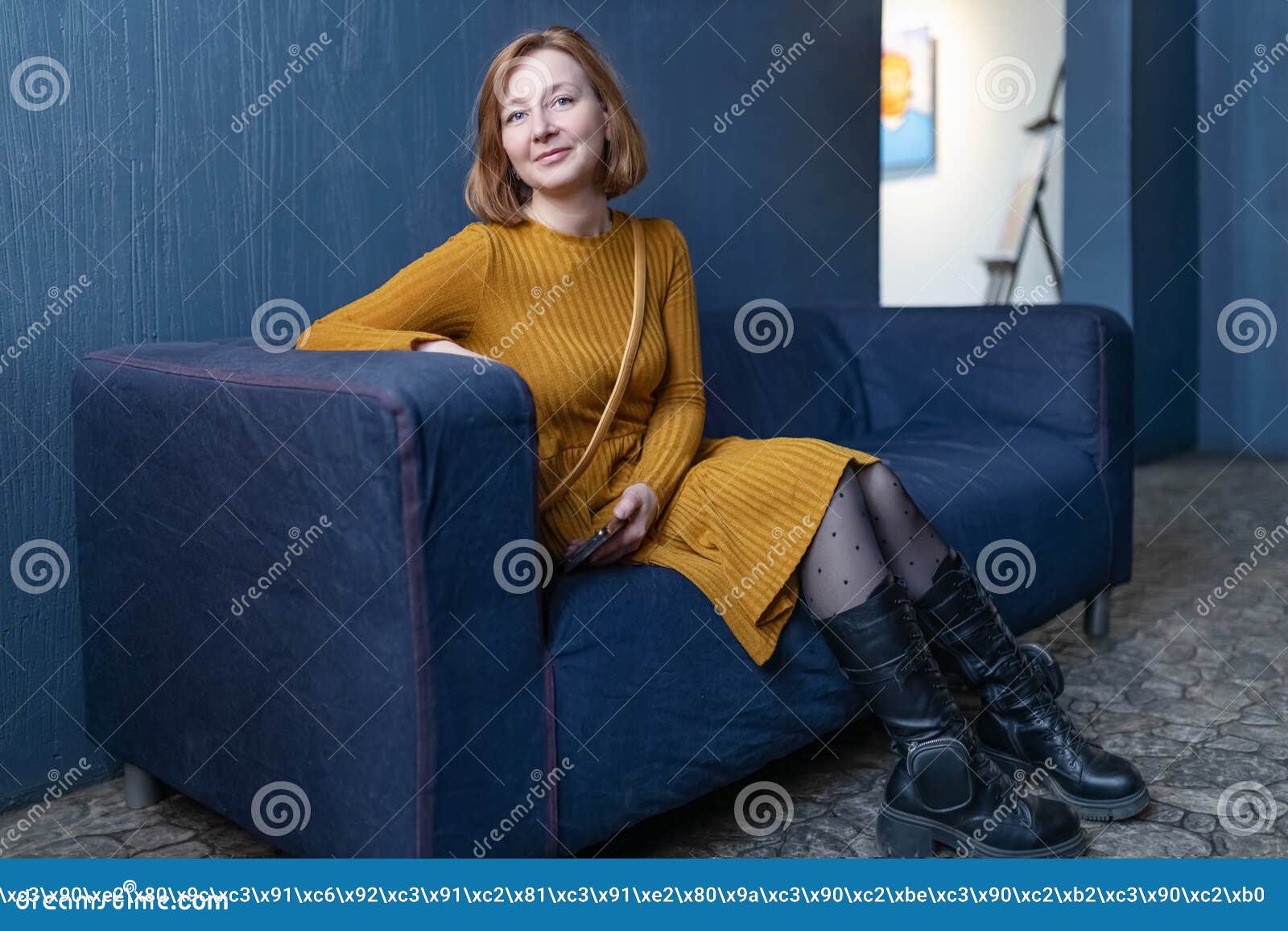 A Young Woman With Red Hair Is Sitting On The Sofa The Concept Of Rest