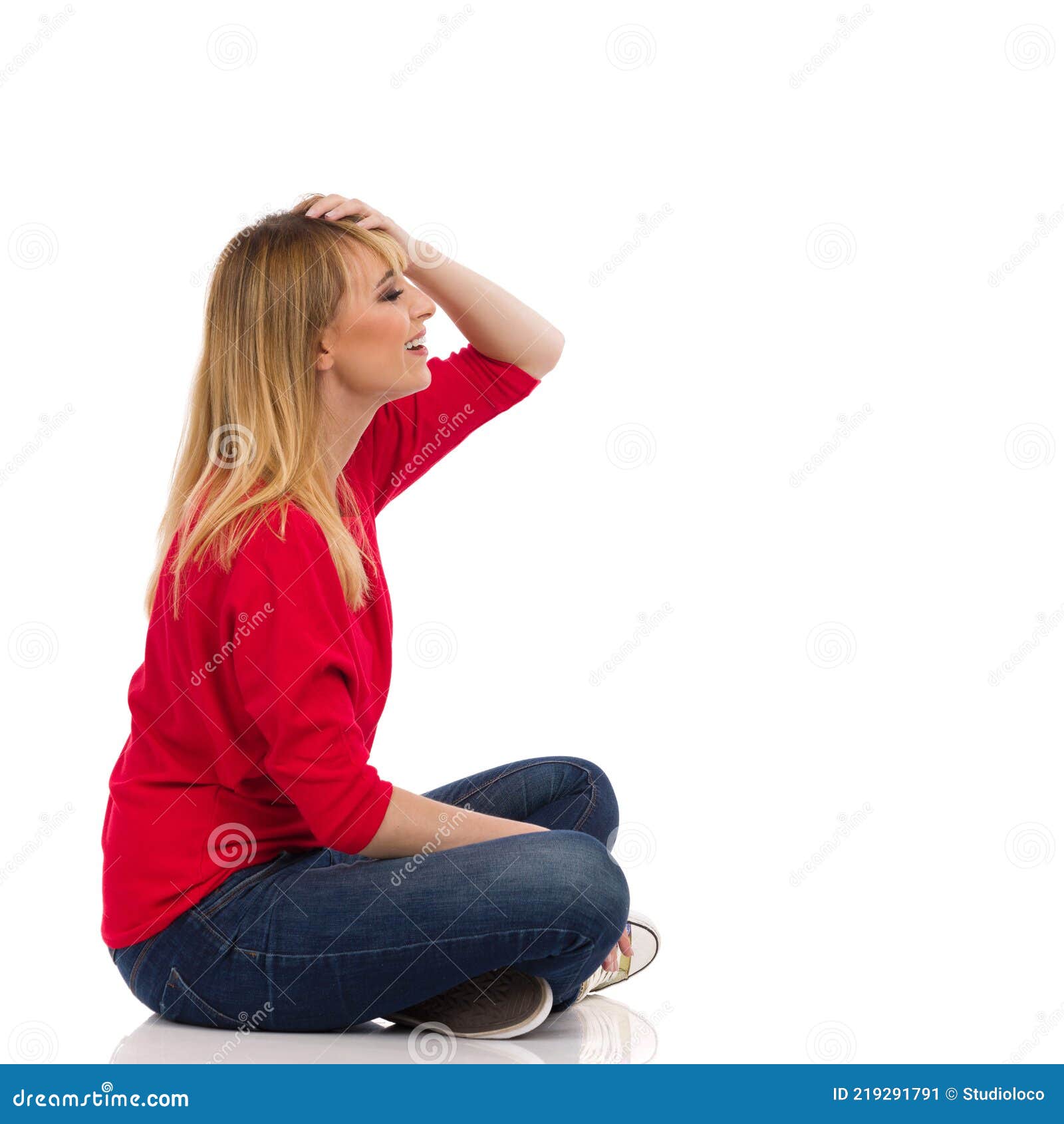 Smiling Young Woman Is Sitting On A Floor And Is Holding Her Head Side