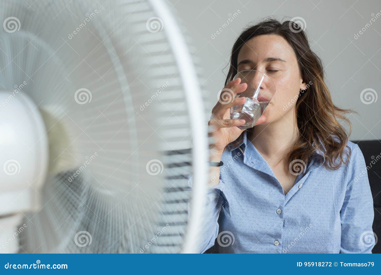 Young Woman Refreshing in Front of Cooling Fan Stock Photo - Image of ...