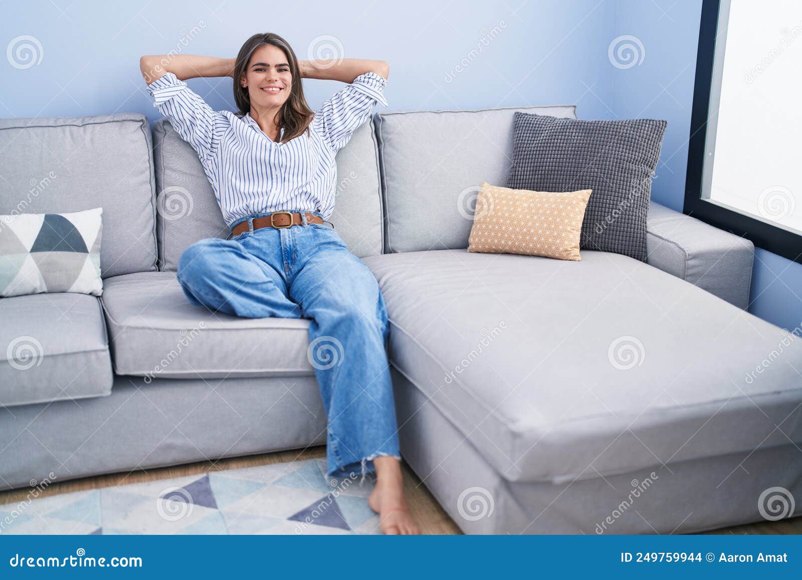 Young Woman Relaxed with Hands on Head Sitting on Sofa at Home Stock ...