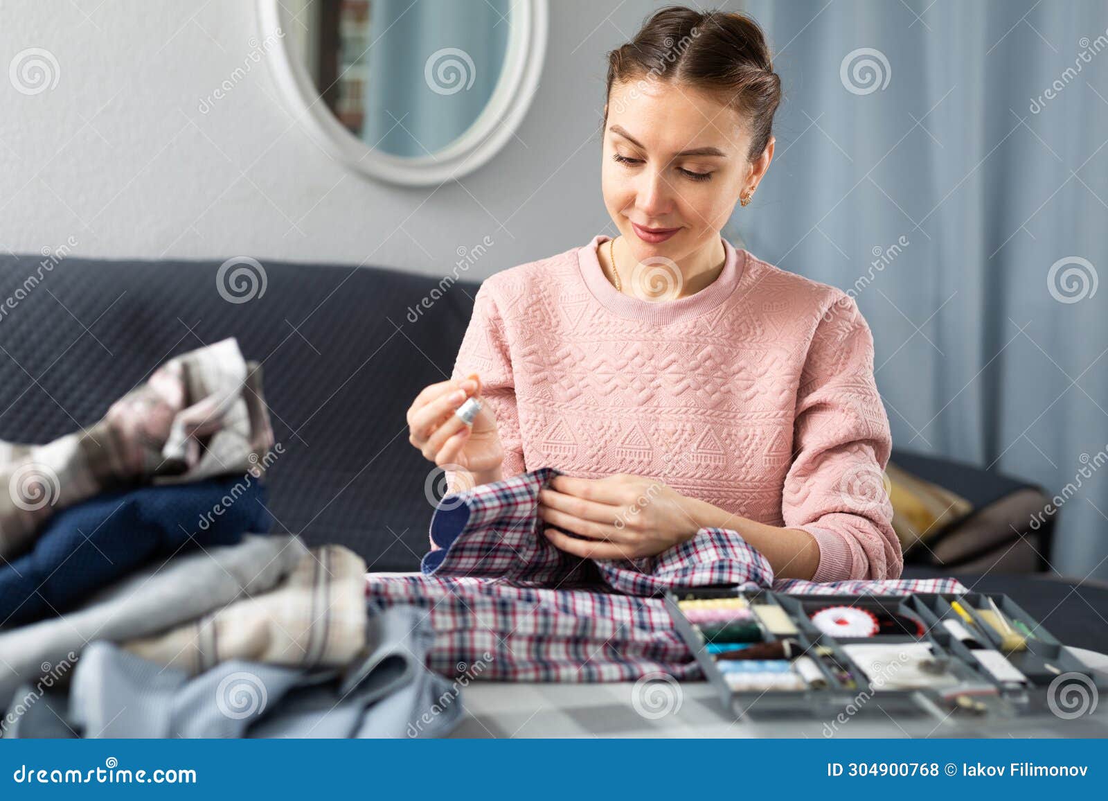 Woman Repairing Clothes with a Needle and Thread Stock Photo - Image of ...