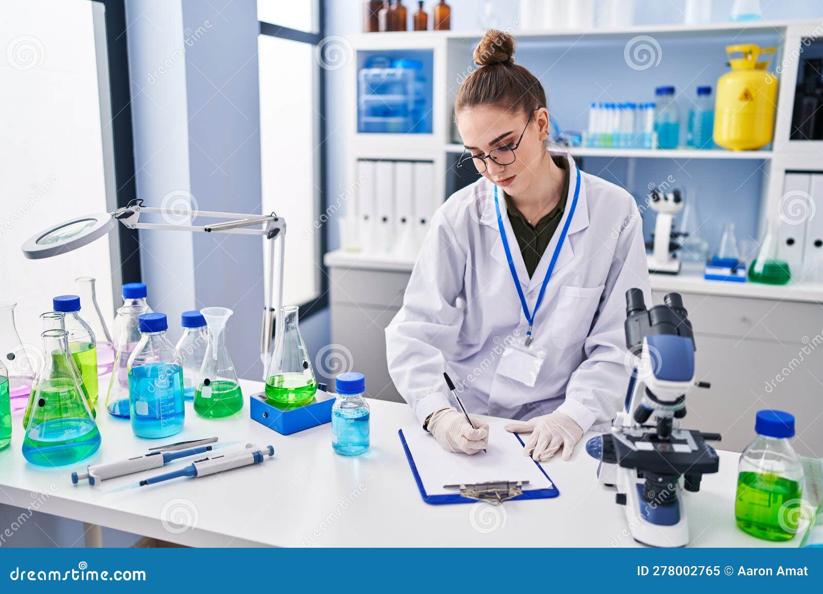 Young Woman Scientist Measuring Liquid Writing on Document at ...