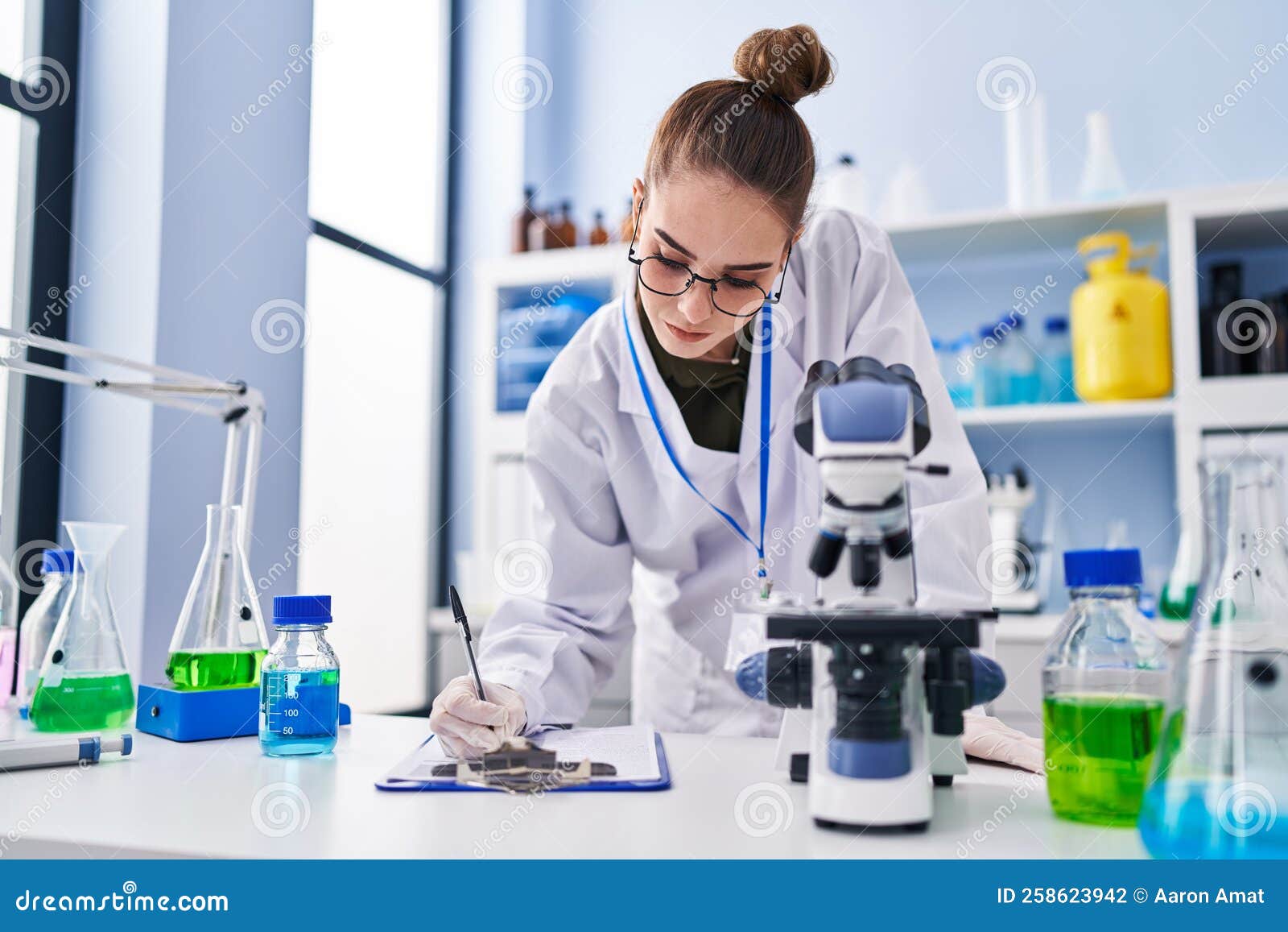 Young Woman Scientist Writing on Clipboard at Laboratory Stock Photo ...