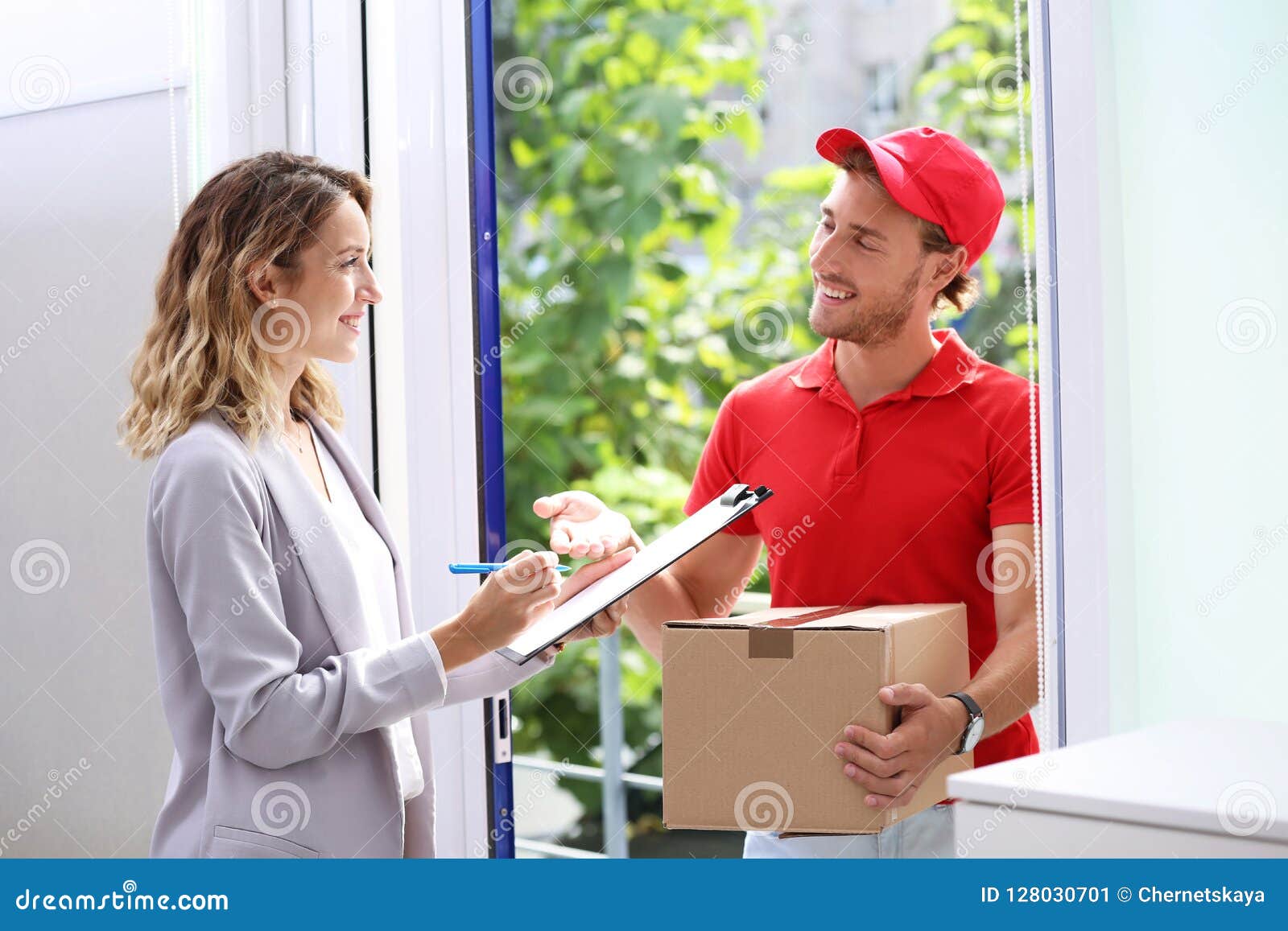Young Woman Signing Documents after Receiving Parcel from Courier Stock ...