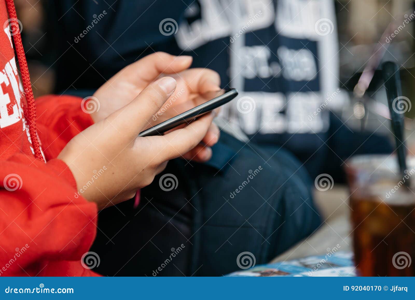 Young Woman Sitting in the Bar Texting on Phone Stock Photo - Image of ...