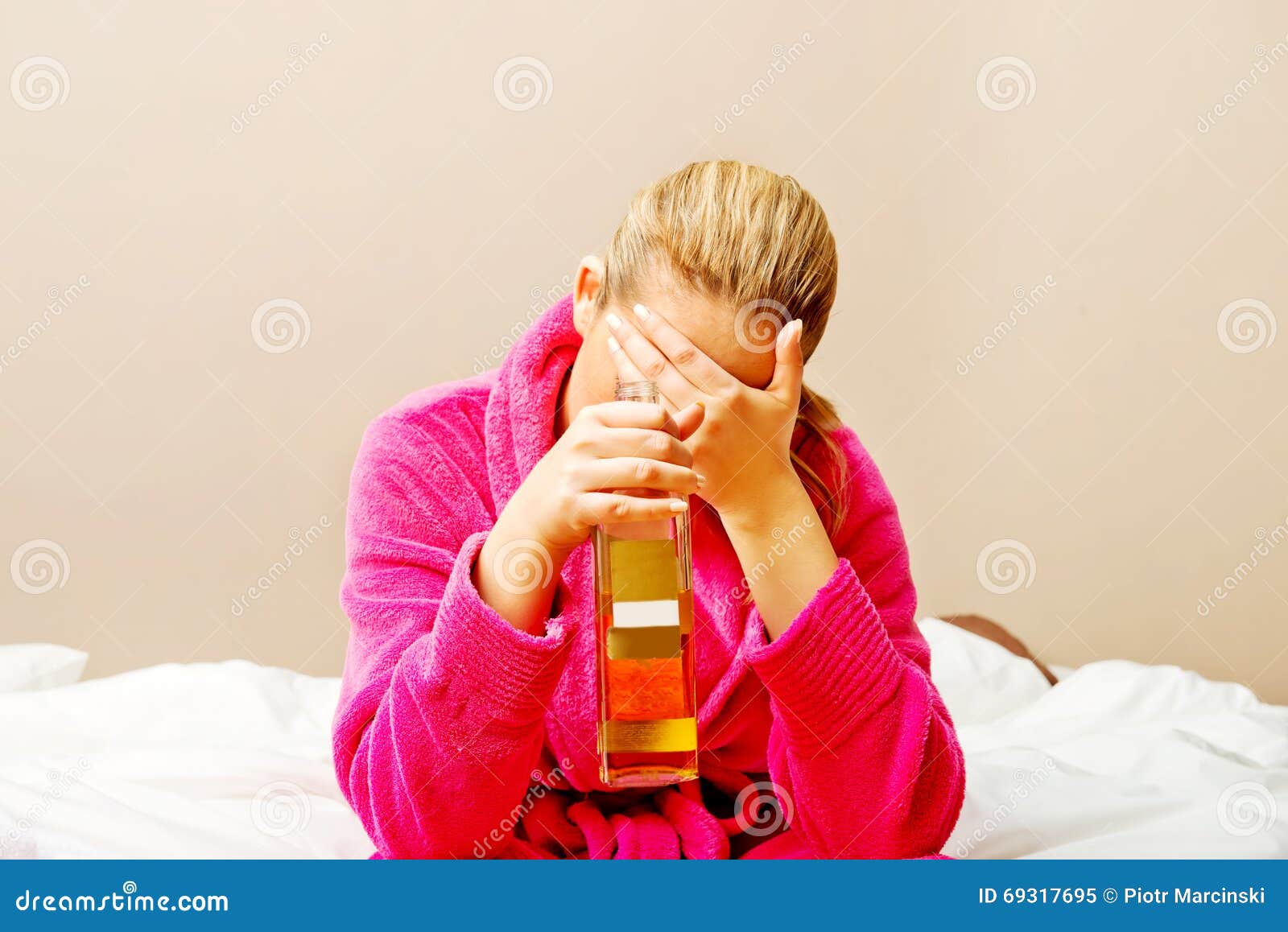 Young Woman Sitting on the Bed Crying and Drinking Whiskey Stock Image ...