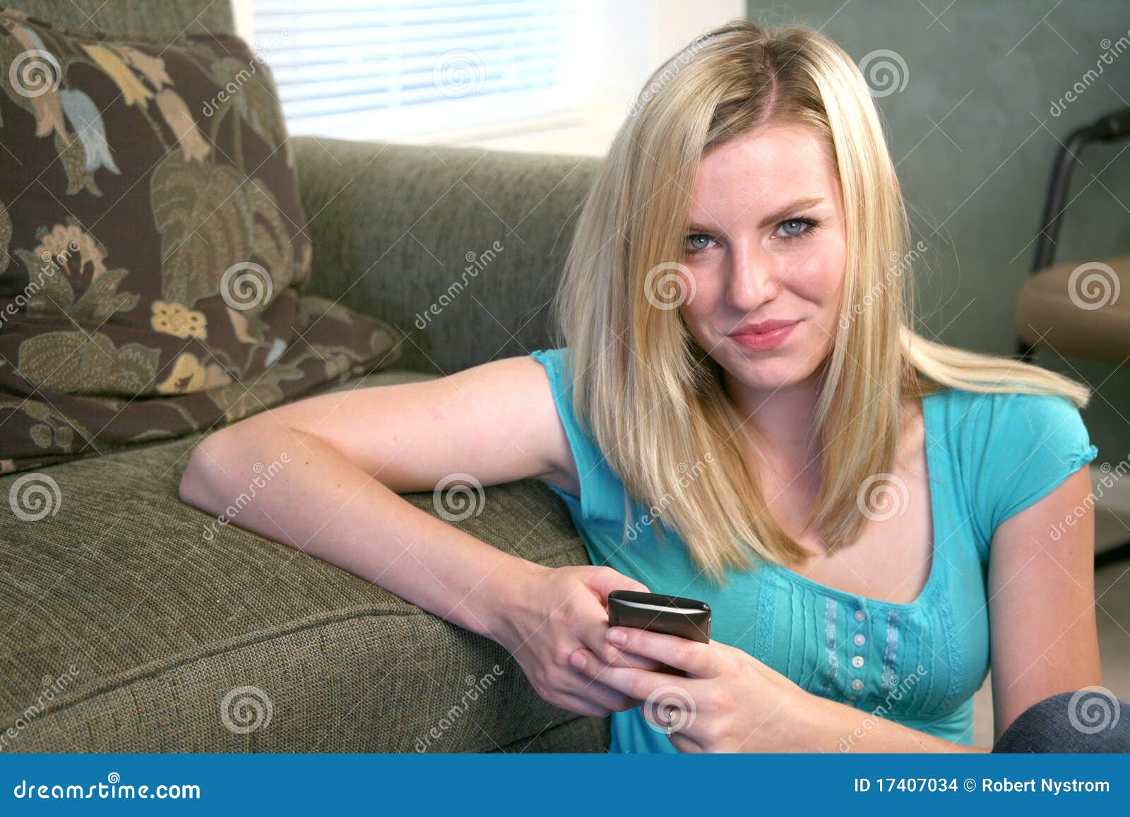A Young Woman Sitting by Her Couch Texting Stock Photo - Image of text ...
