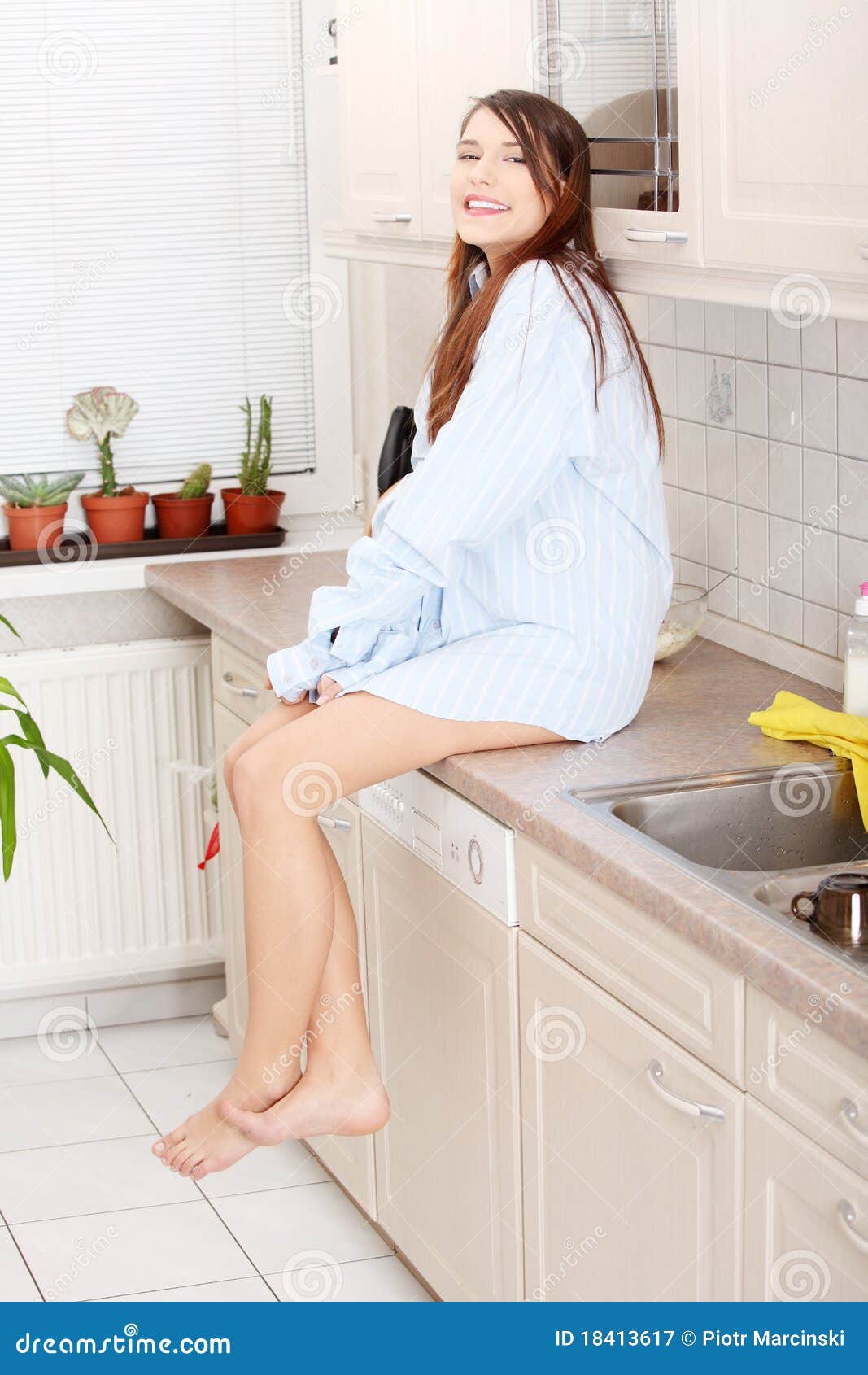Young Woman Sitting on Kitchen Counter Stock Image - Image of indoors ...