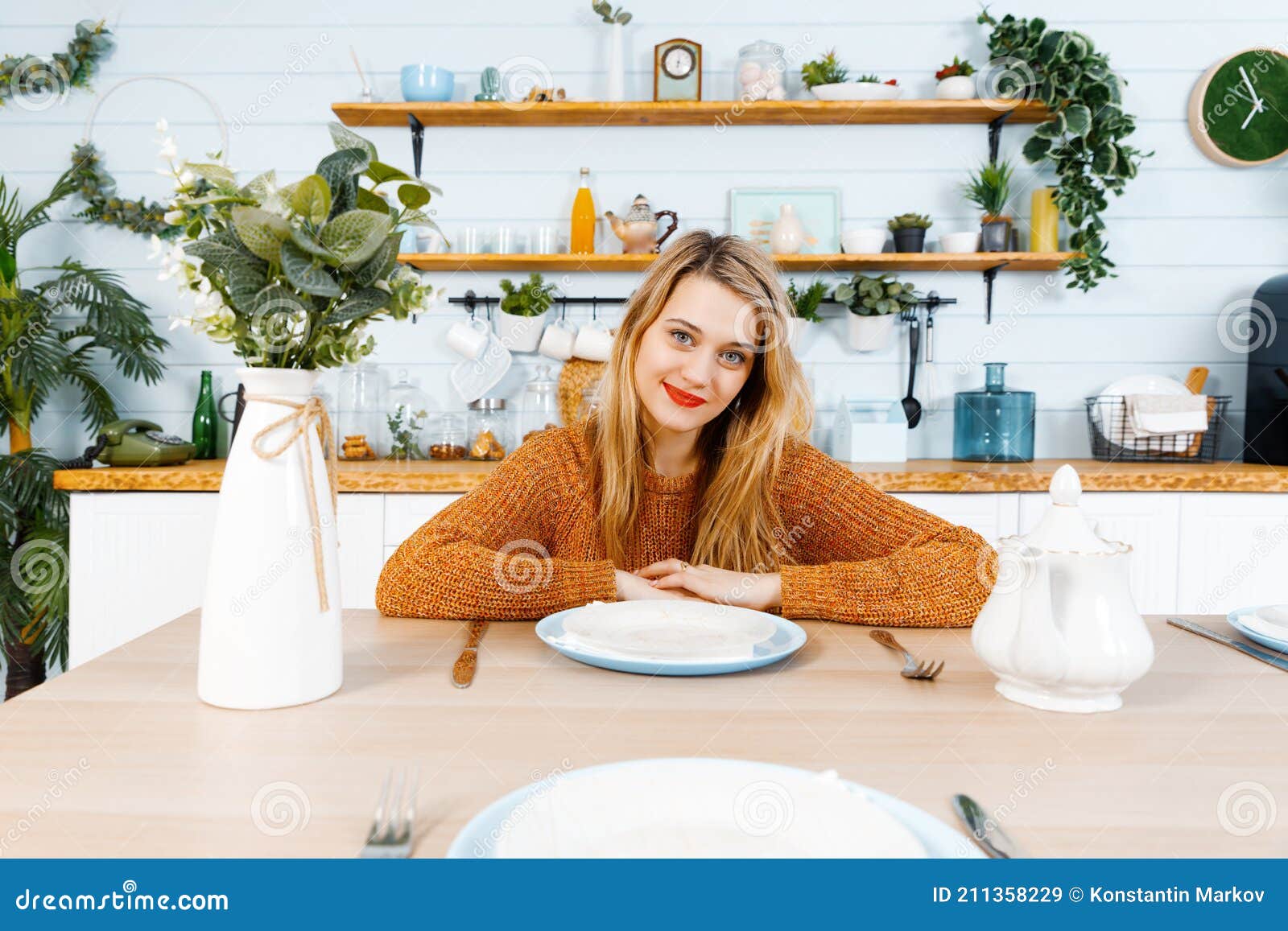 Young Woman Sitting at the Kitchen Table in Front of an Empty Plate ...