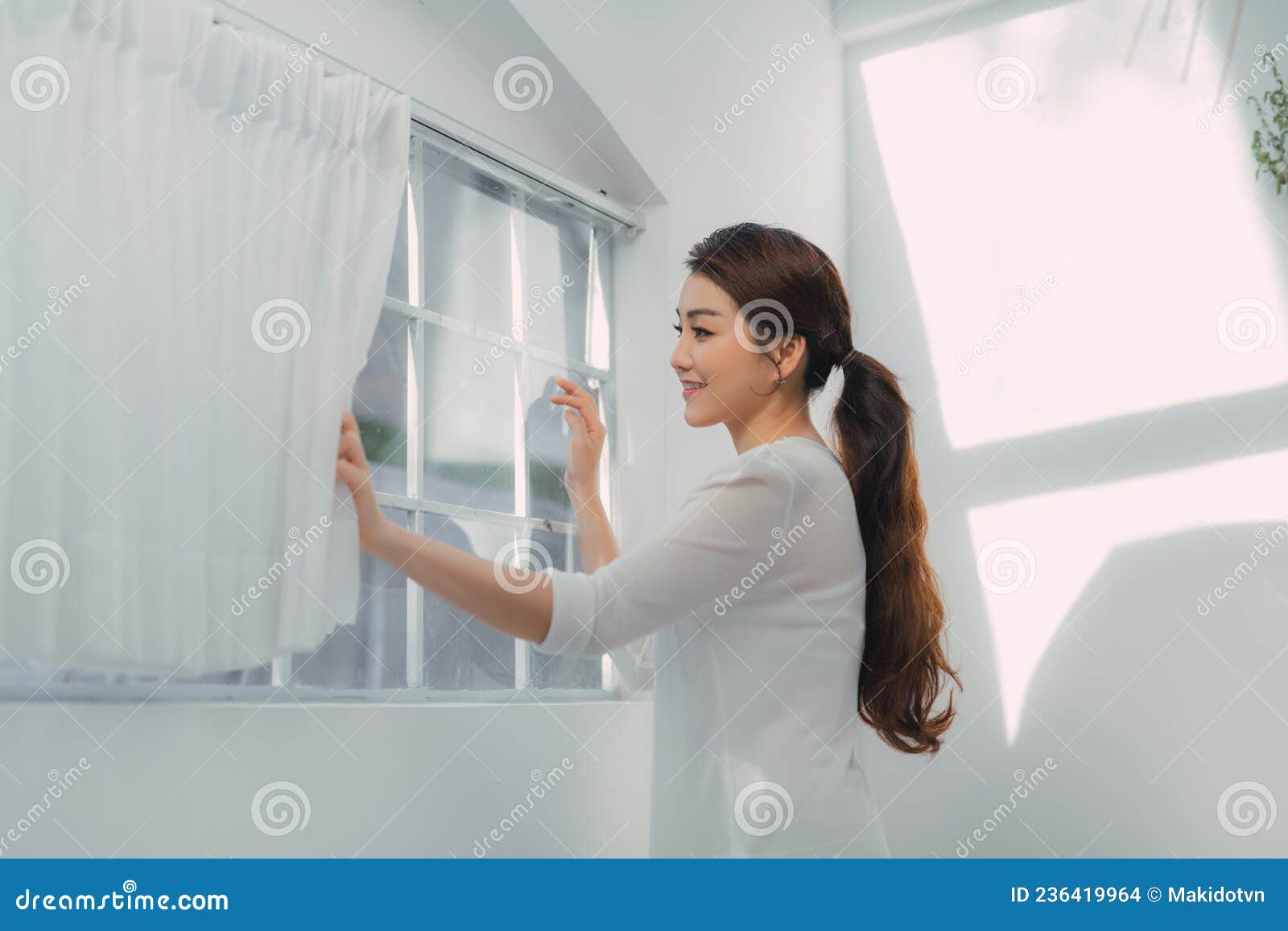Young Woman Standing in Front of the Bedroom Window Looking Outside ...