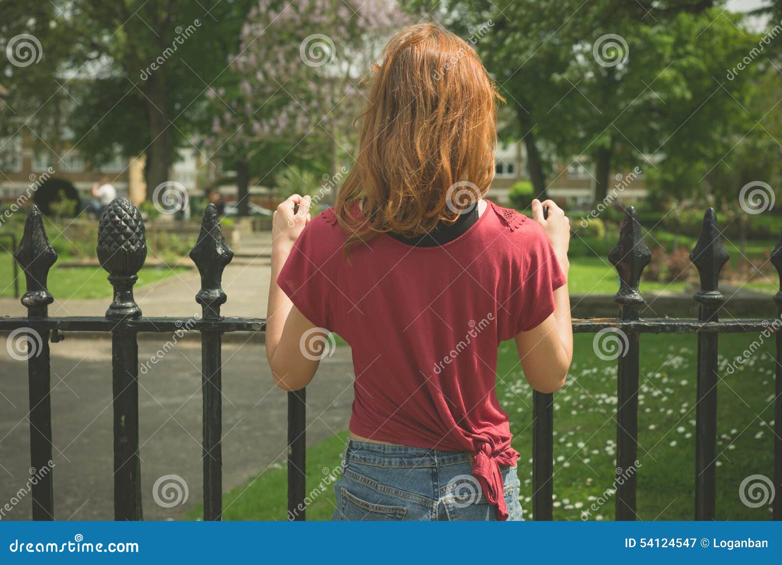 Young Woman Standing by Gate Outside Park Stock Image - Image of ...