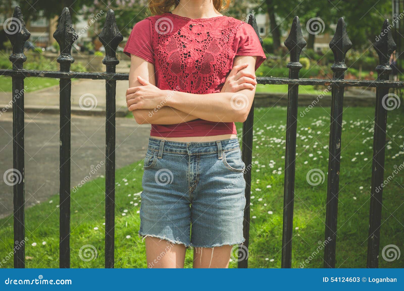 Young Woman Standing by Gate Outside Park Stock Image - Image of purple ...