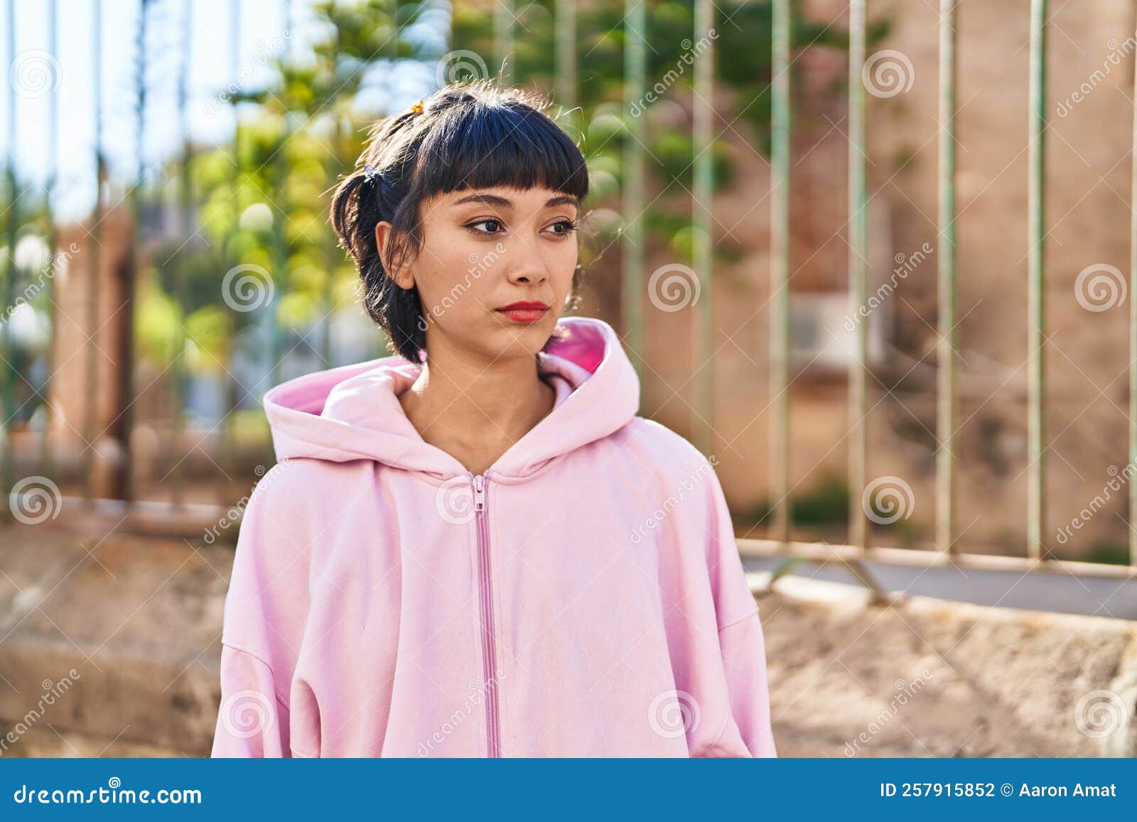 Young Woman Standing with Relaxed Expression at Street Stock Photo ...