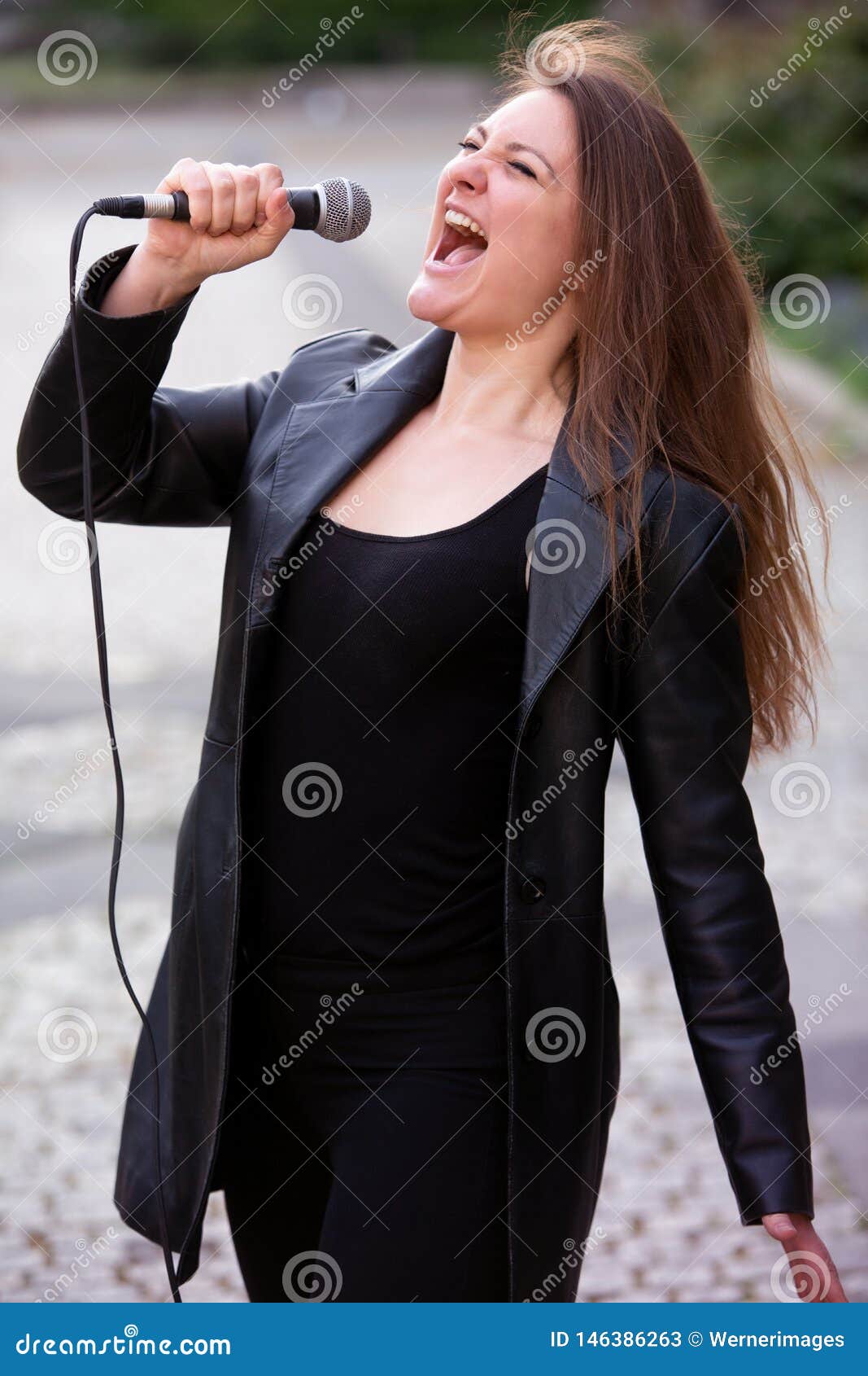 Young Woman Standing and Singing with Microphone Outdoors Stock Image ...