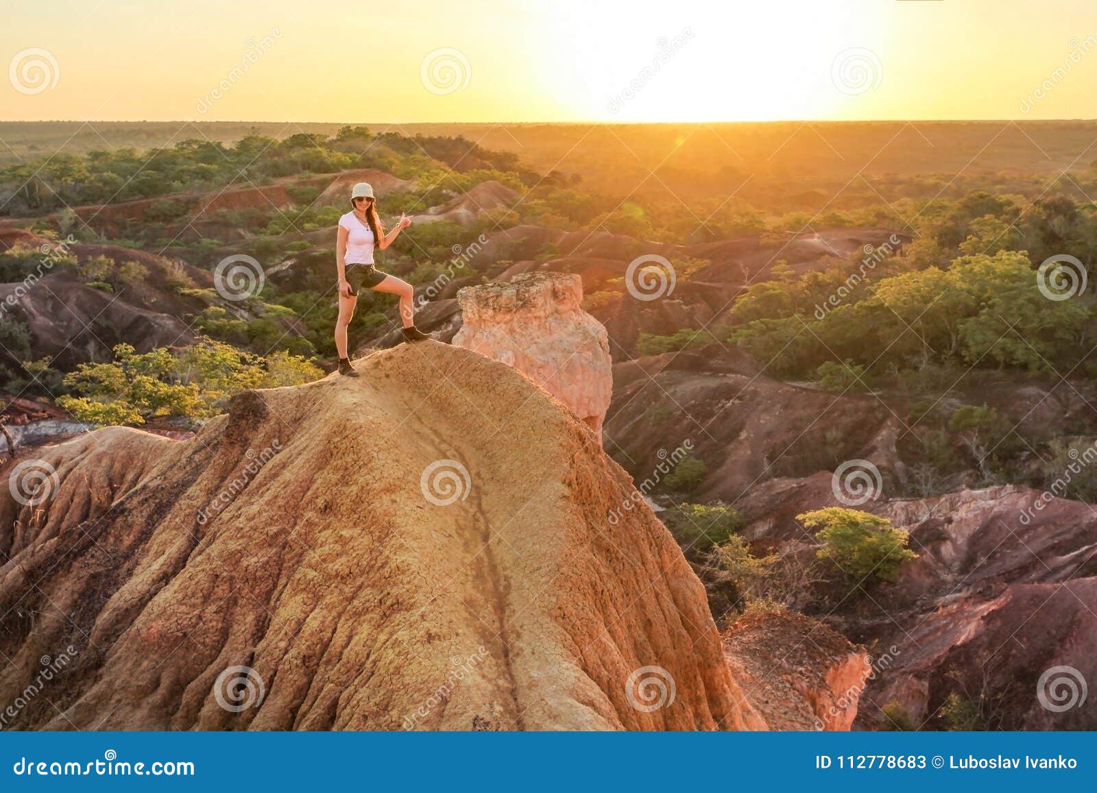 Young Woman Standing on Top of the Hill, Pointing at the Sun Stock ... Young Woman Standing on Top of the Hill, Pointing at the Sun Stock ...