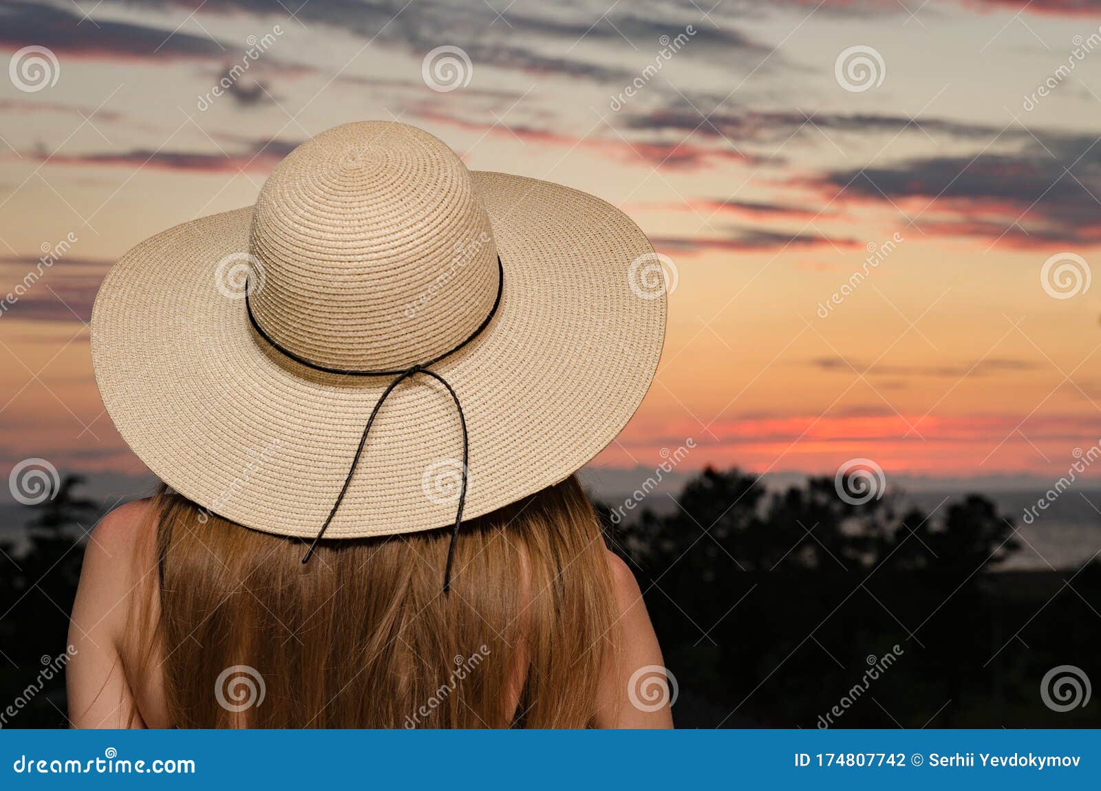 Young Woman in Straw Hat with Large Fields, Watching Sunset. Back View ...