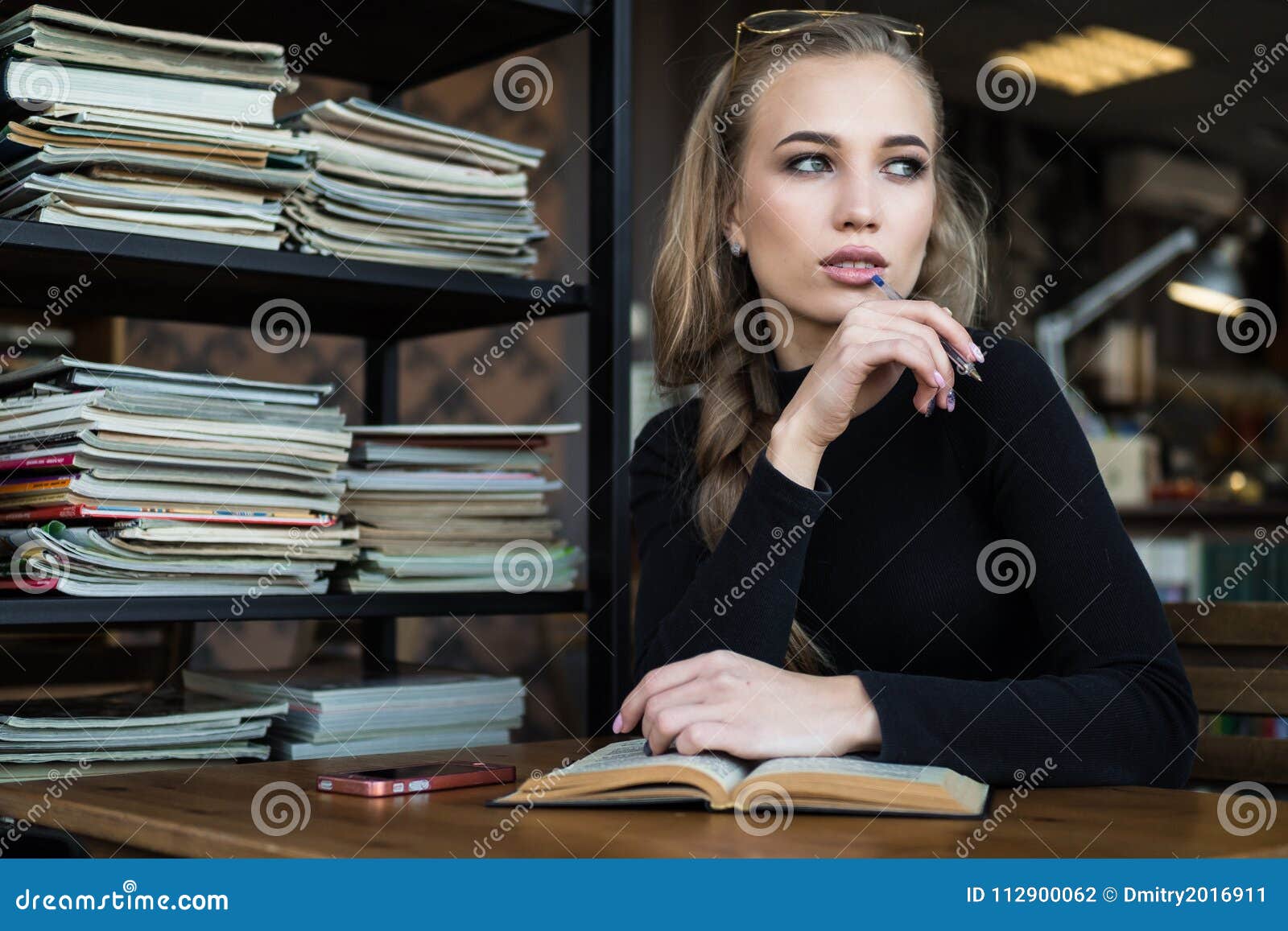 Young Woman Student, Bored To Read Book in a Library Stock Photo ...