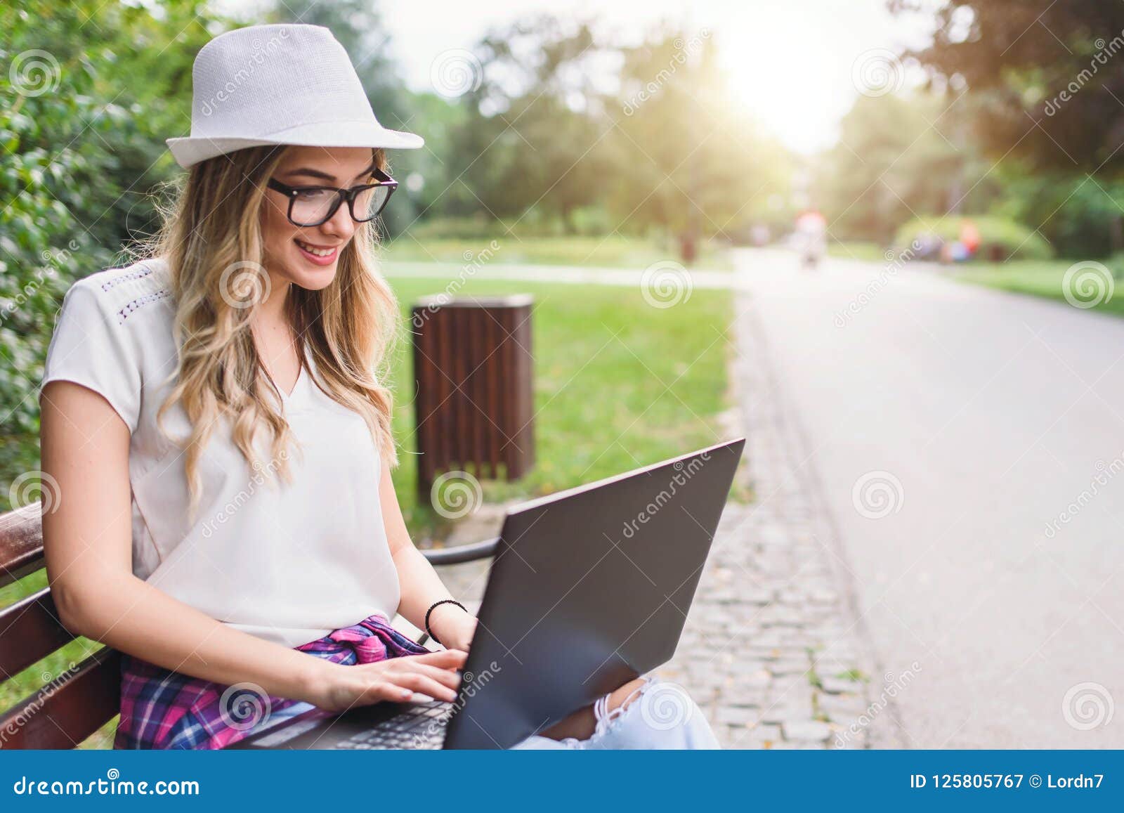 Young Woman Student Sitting on Park Bench Working on Laptop Computer ...