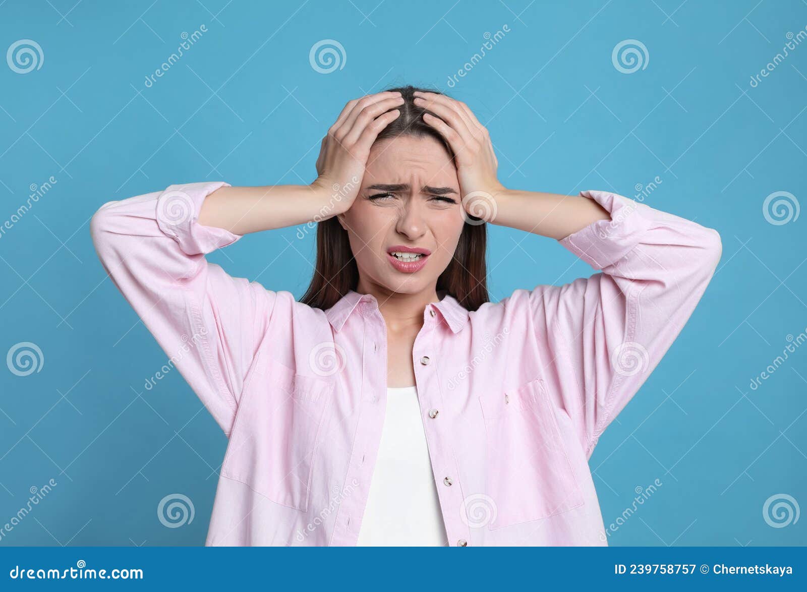 Young Woman Suffering from Headache on Light Blue Background Stock ...