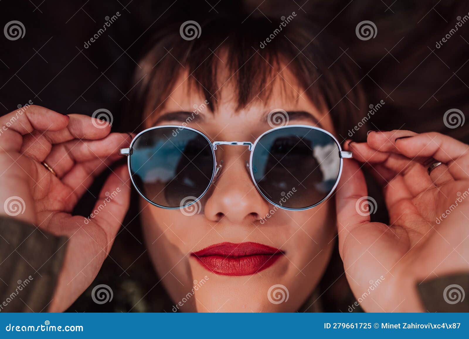 A Young Woman With Sunglasses Lying On The Grass Showing Her Beautiful