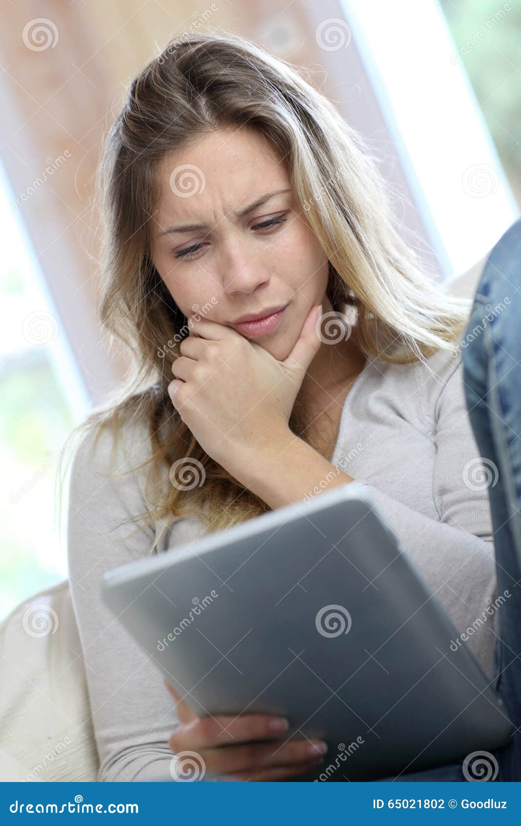 Young Woman on Tablet with Sad Look Stock Photo - Image of relaxing ...