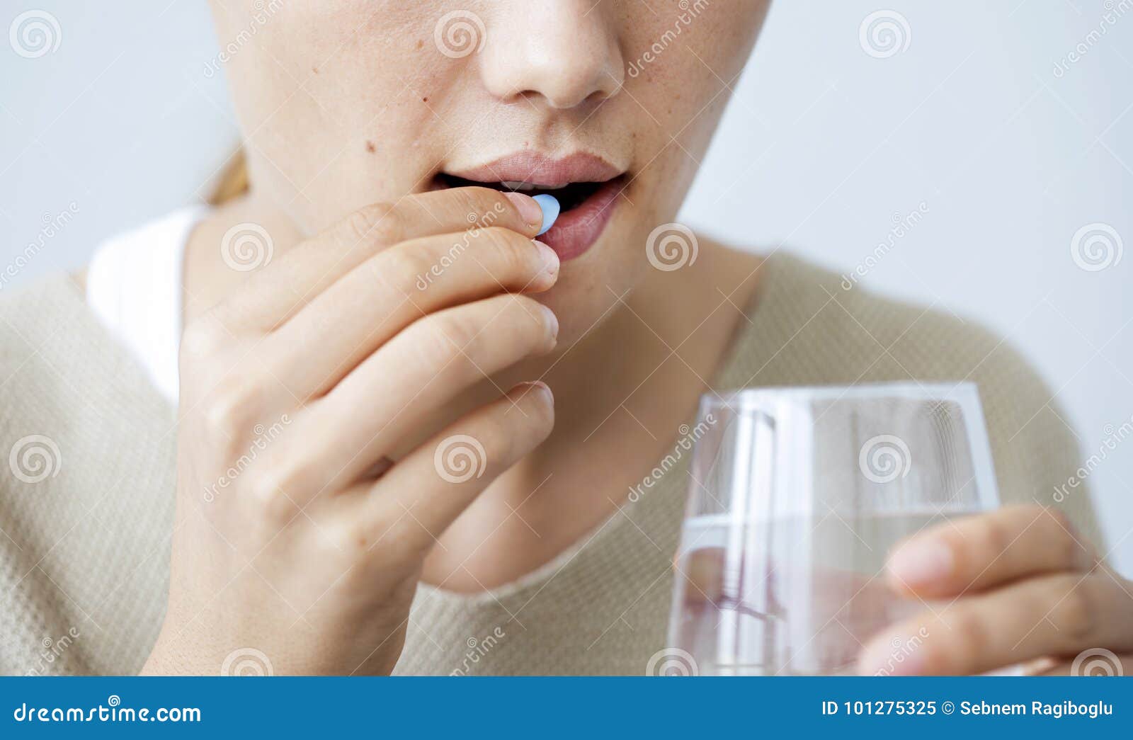 Young woman taking a pill stock image. Image of close - 101275325