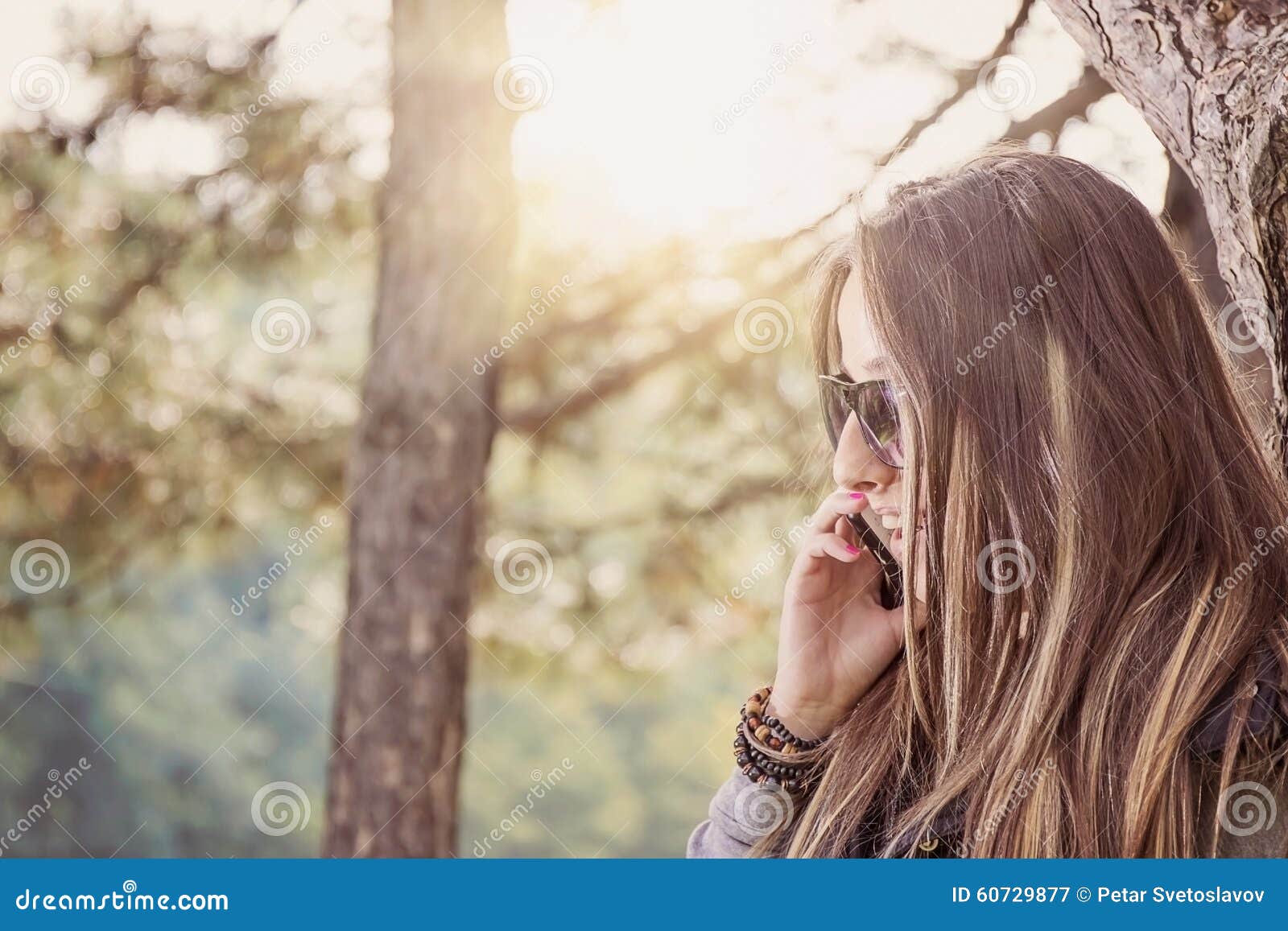 Young Woman Talking on the Phone Outside Under a Tree Stock Image ...