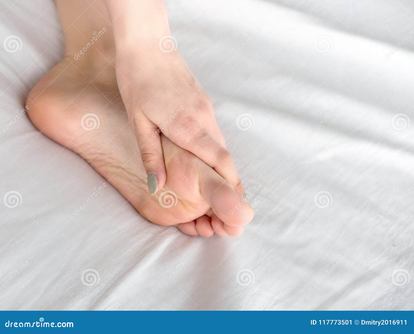 Young Woman Touching Her Leg on Bed Stock Image - Image of hand, female ...