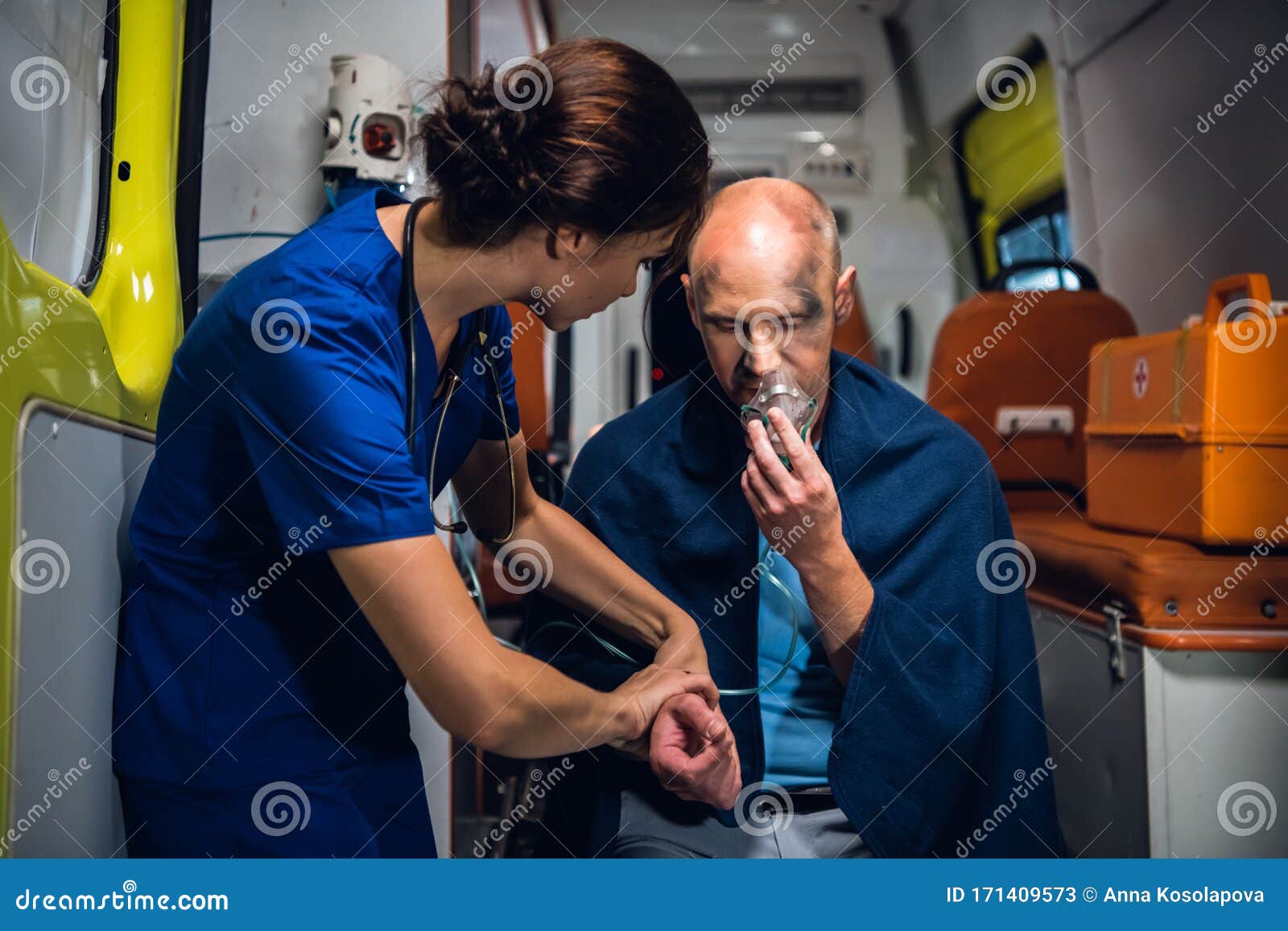 Young Woman In Uniform Holds A Hand Of Man Who Sits In Oxygen Mask In