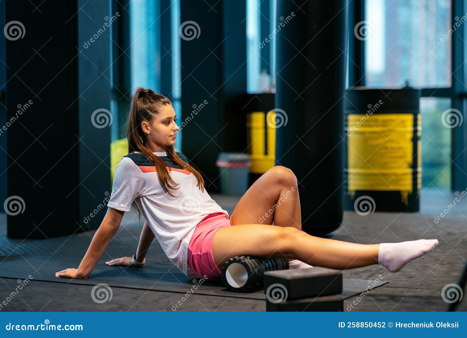 Young Woman Using a Foam Roller while Doing Stretching Exercises Stock ...