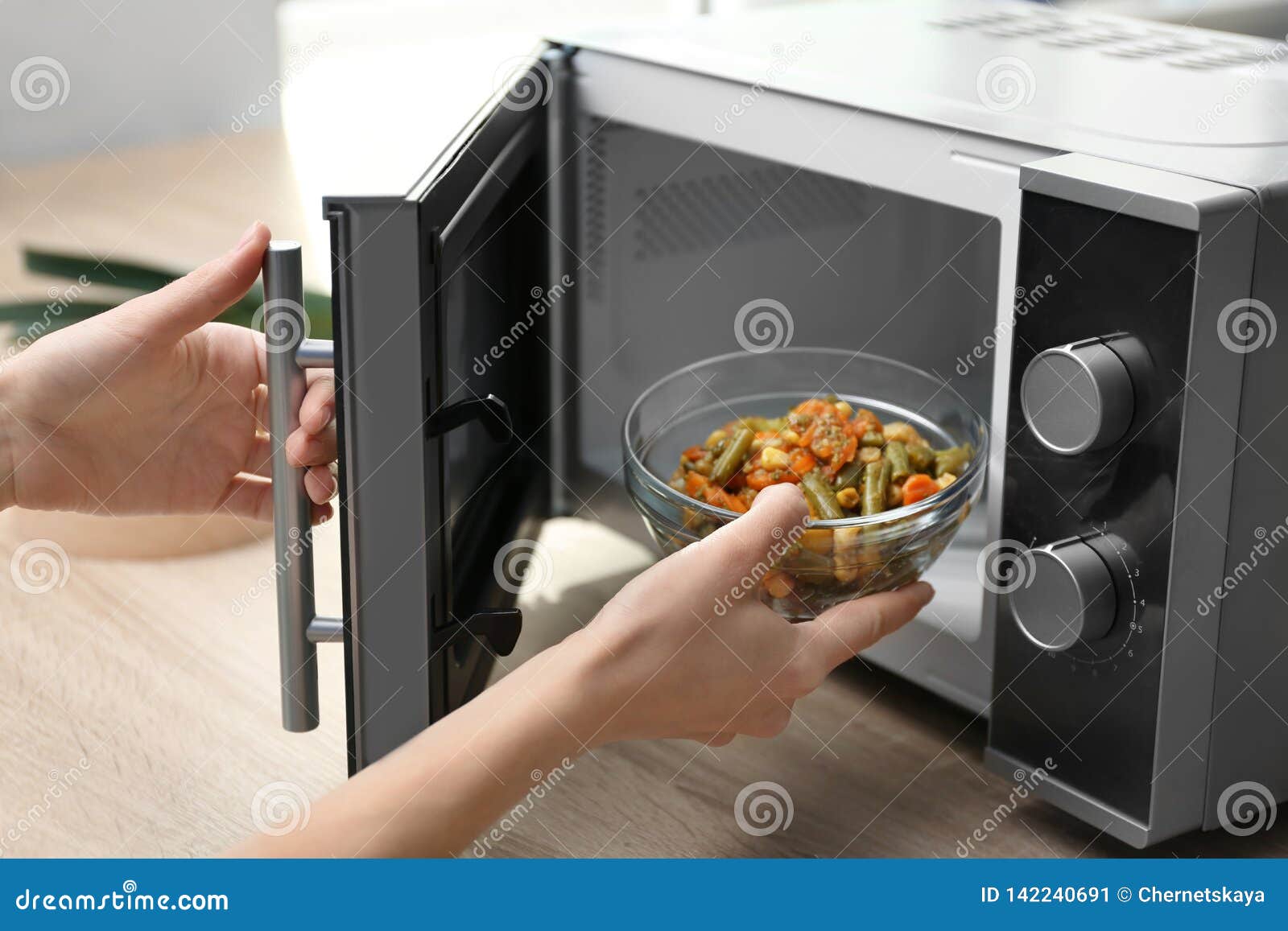 Young Woman Using Microwave Oven on Table Stock Image - Image of ...