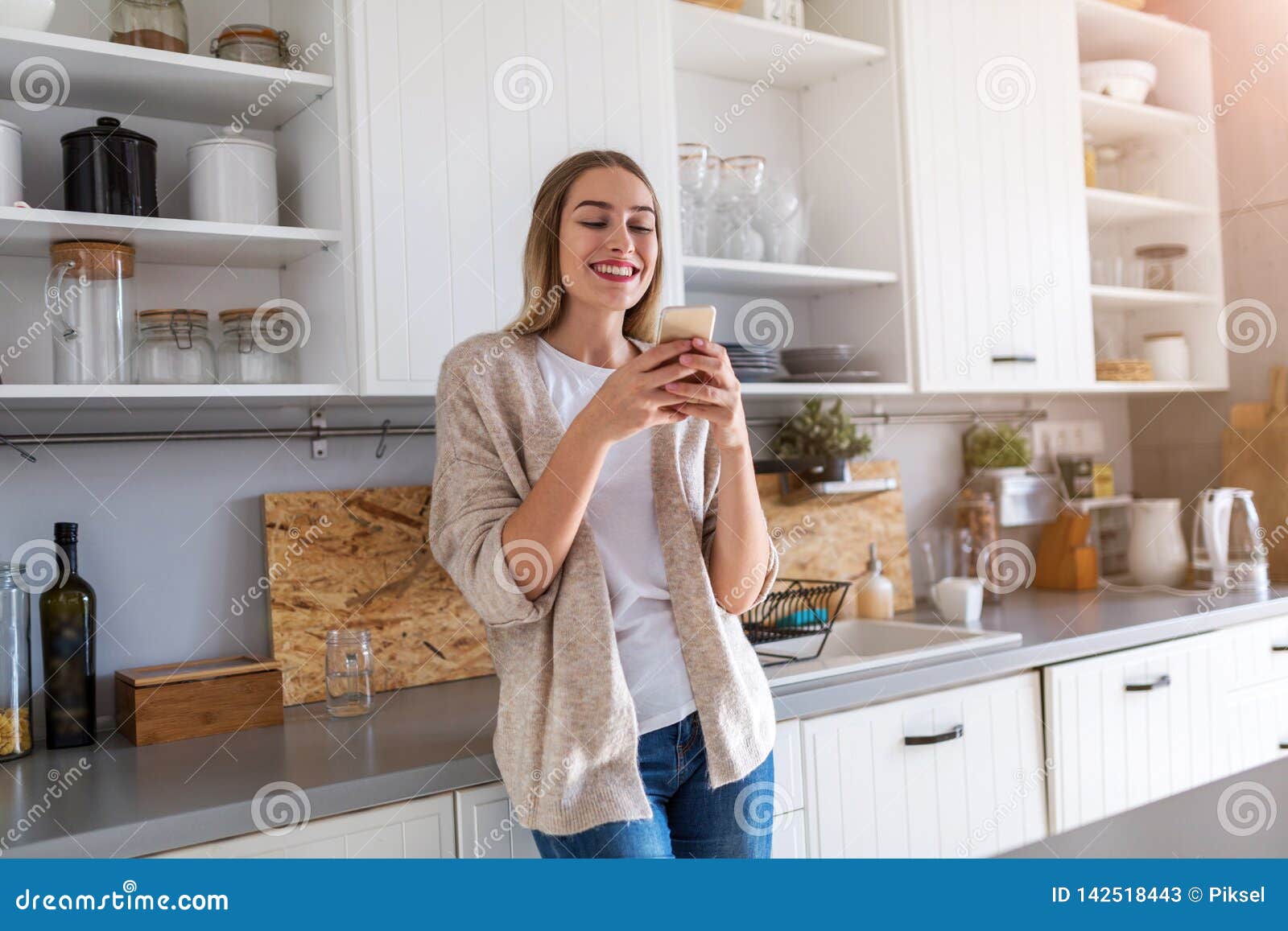 Young Woman Using Mobile Phone in the Kitchen Stock Image - Image of ...