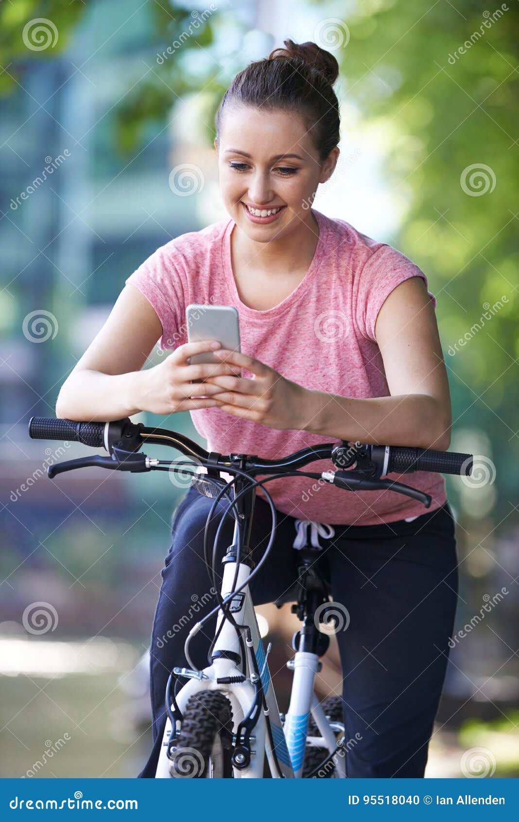 Young Woman Using Mobile Phone Whilst Out on Cycle Ride Stock Photo ...