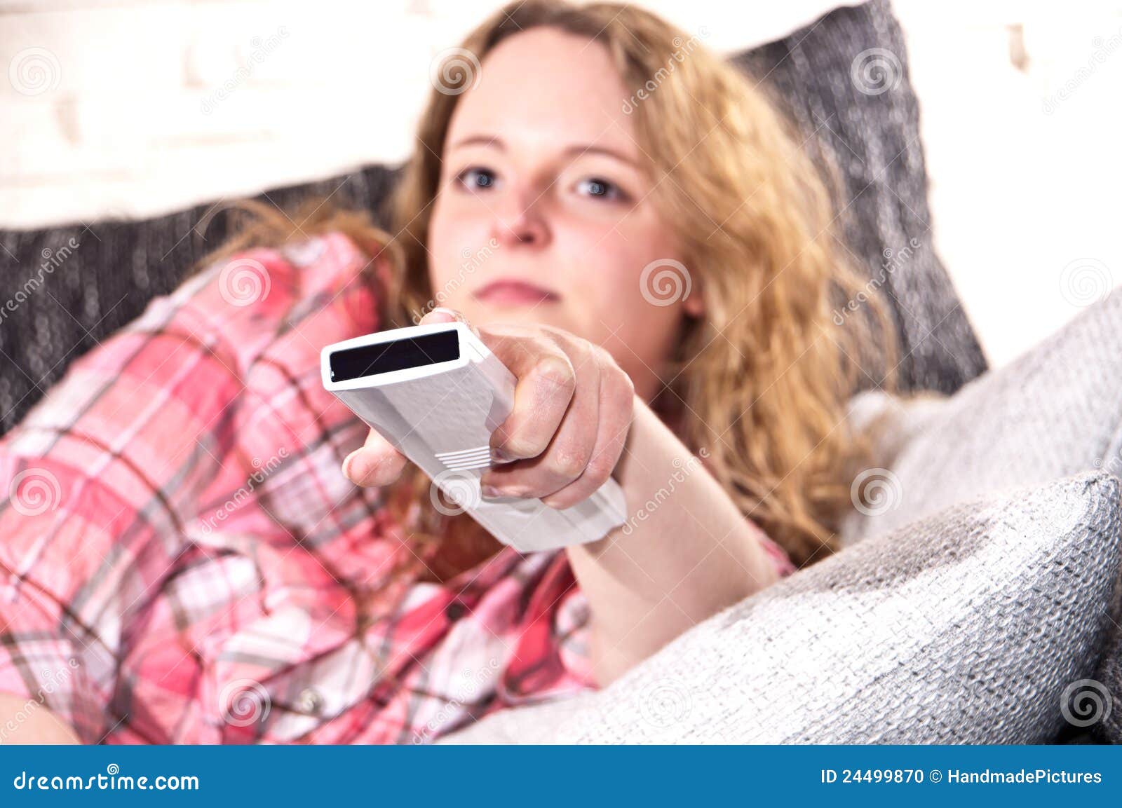 Young Woman is Using a Remote Control Stock Photo - Image of pillows ... Young Woman is Using a Remote Control Stock Photo - Image of pillows ...