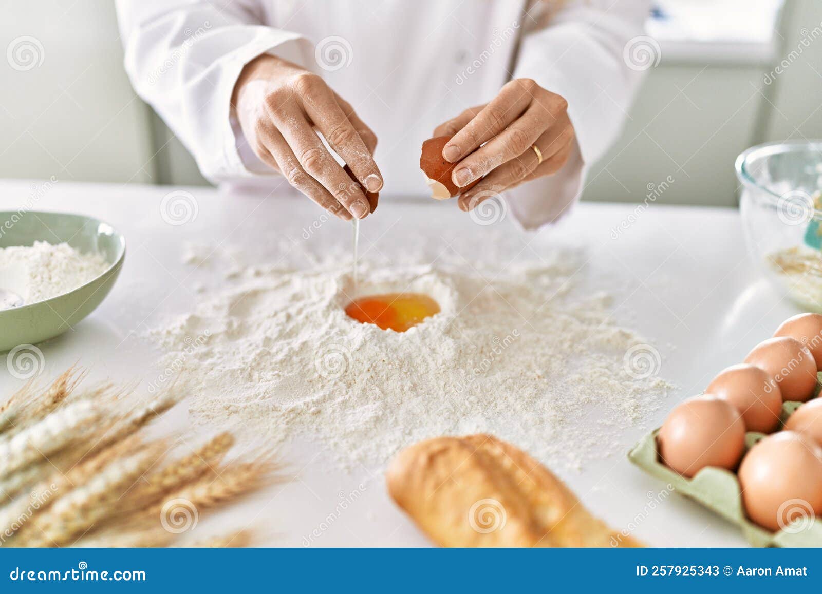 Young Woman Wearing Cook Uniform Cracking Egg on Flour at Kitchen Stock ...