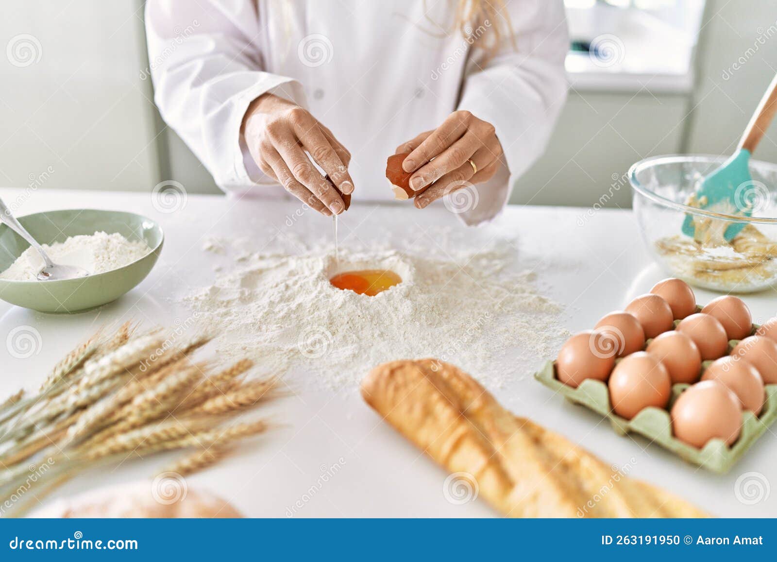 Young Woman Wearing Cook Uniform Cracking Egg on Flour at Kitchen Stock ...