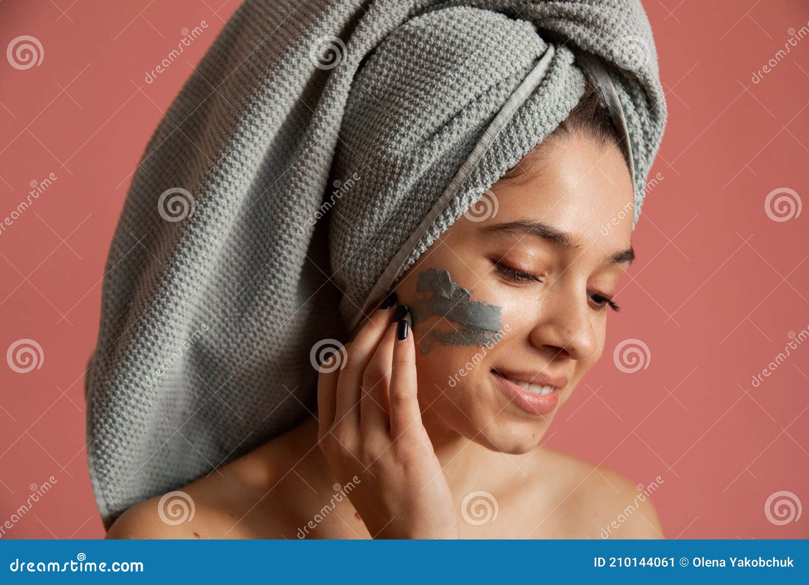 Woman Wearing Grey Towel Applying Clay Mask On Her Face Stock Image