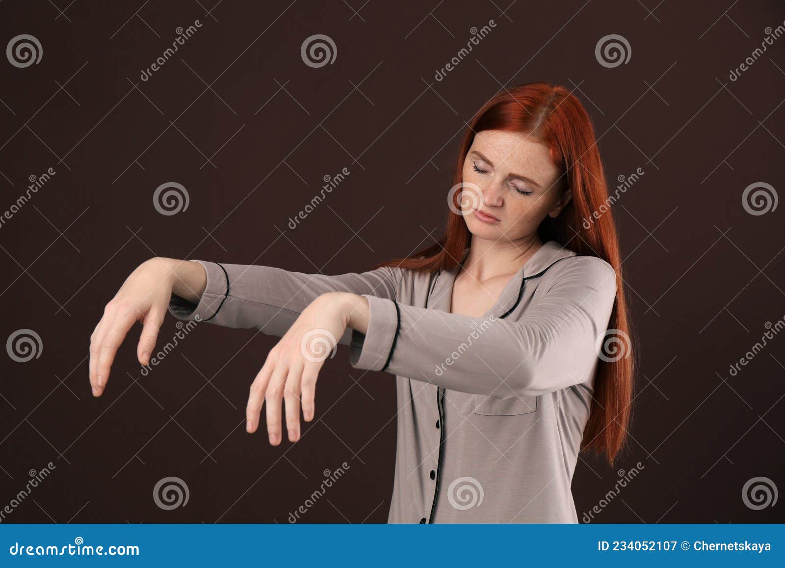 Young Woman Wearing Pajamas in Sleepwalking State on Brown Background ... Young Woman Wearing Pajamas in Sleepwalking State on Brown Background ...