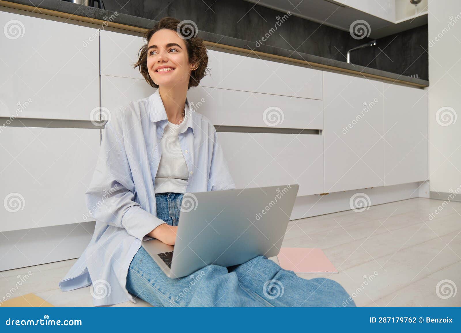 Young Woman Works from Home on Kitchen Floor, Does Homework on Laptop ...